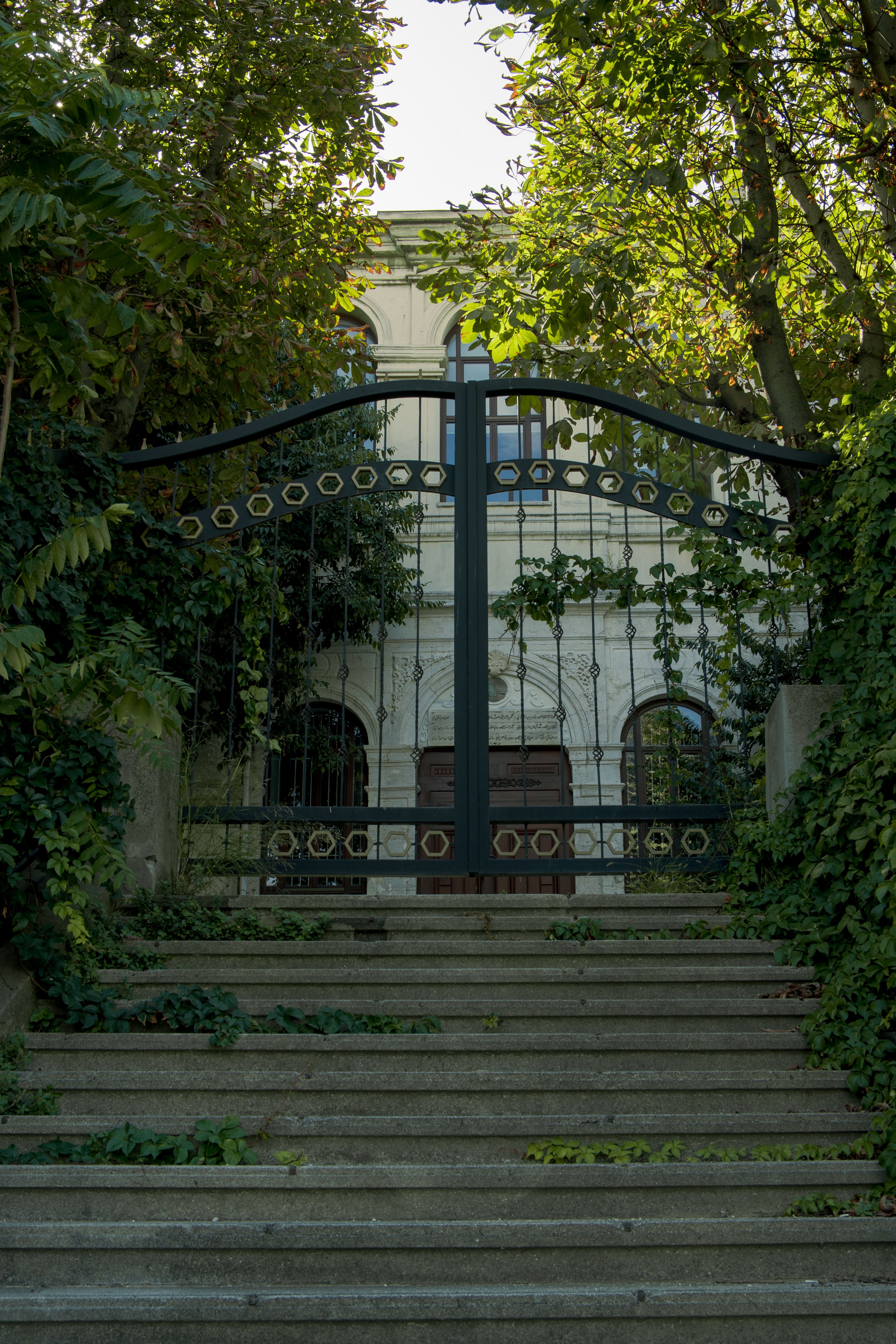 Elegant Mansion Gate Surrounded by Lush Greenery · Free Stock Photo