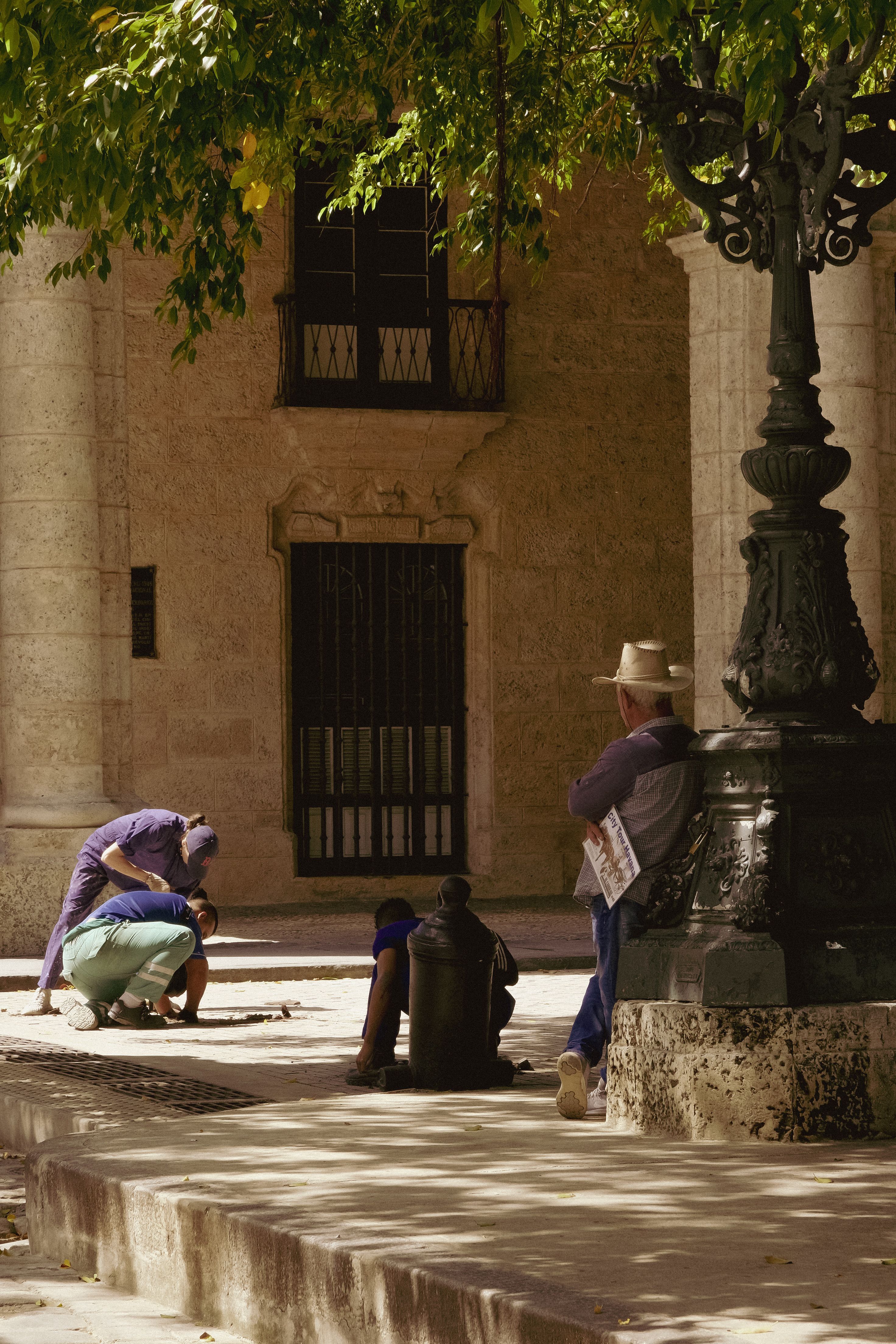 Street Scene with People Resting in Shade · Free Stock Photo