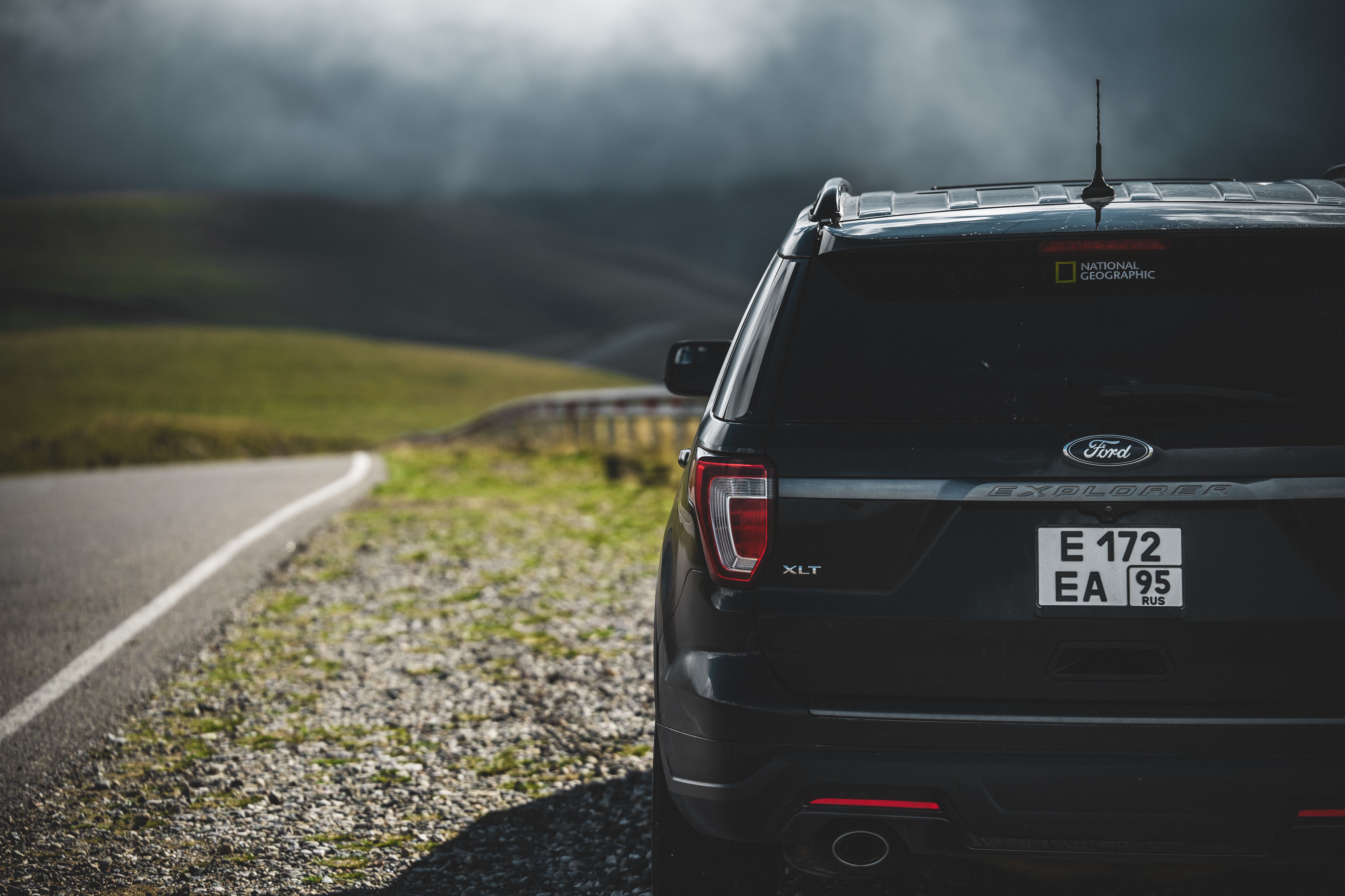 SUV on Scenic Roadside in Hilly Landscape · Free Stock Photo