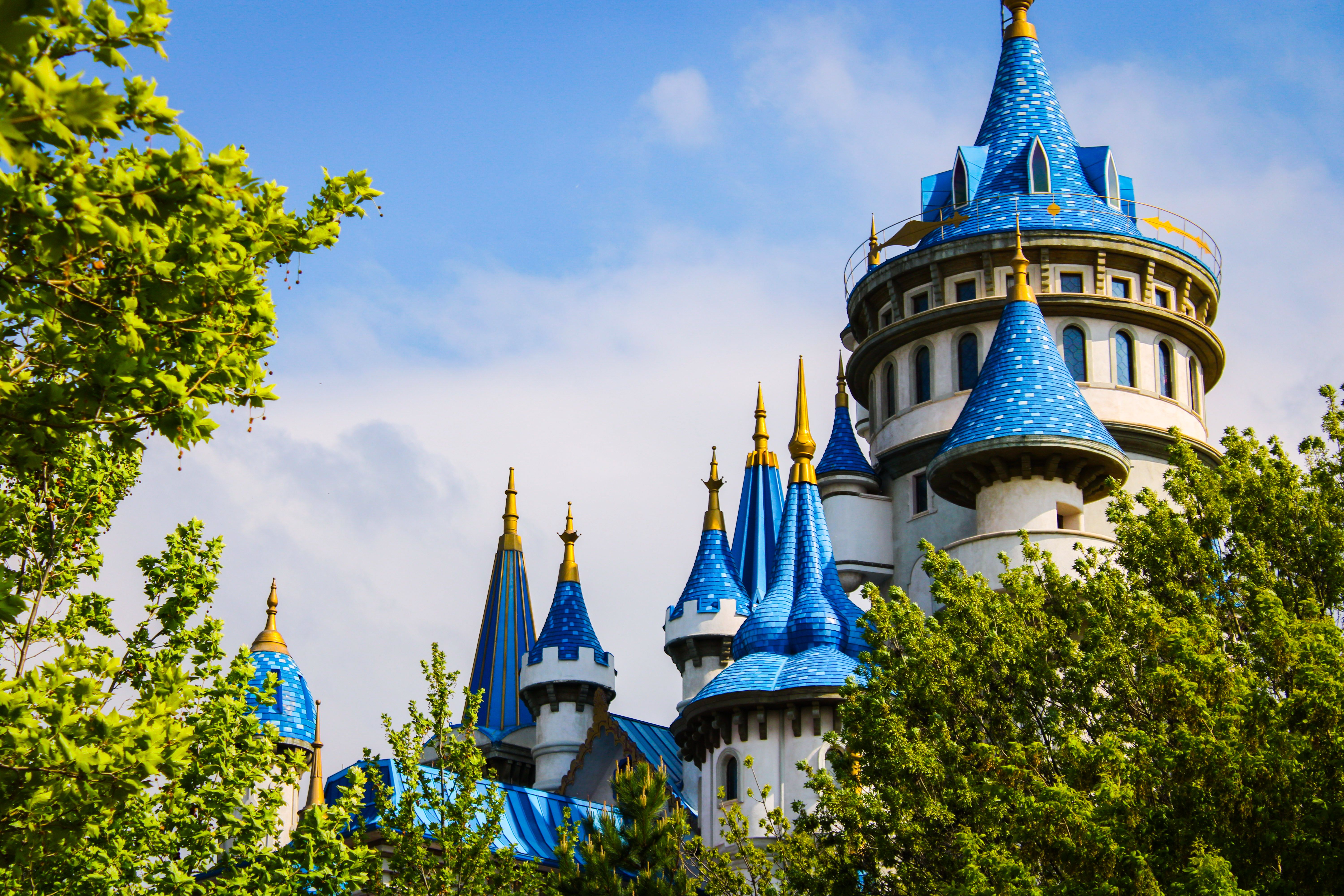 Blue Topped Castle Towers Amidst Lush Trees · Free Stock Photo
