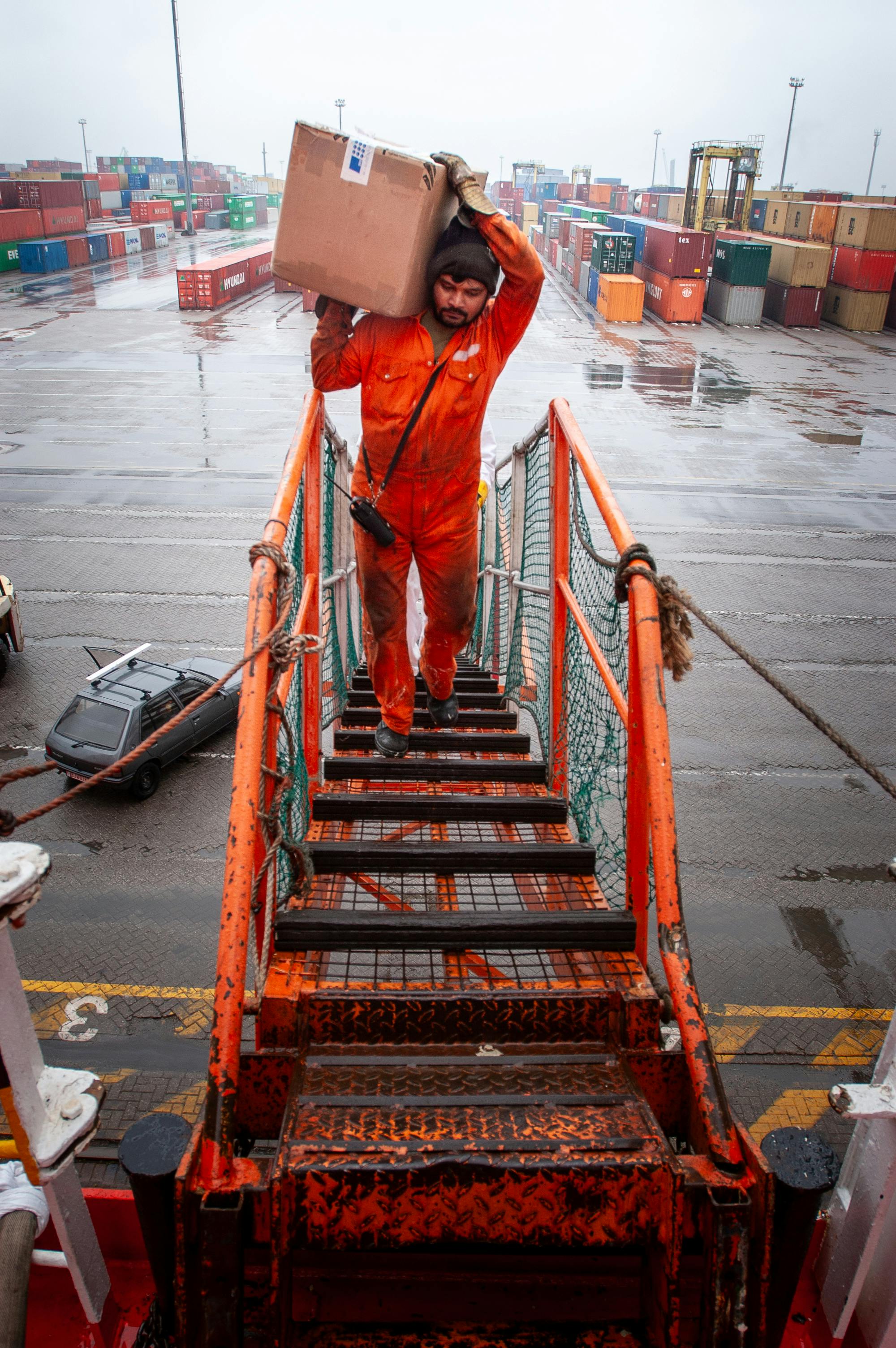Crew Member Carrying Cargo Up Ship Gangway · Free Stock Photo