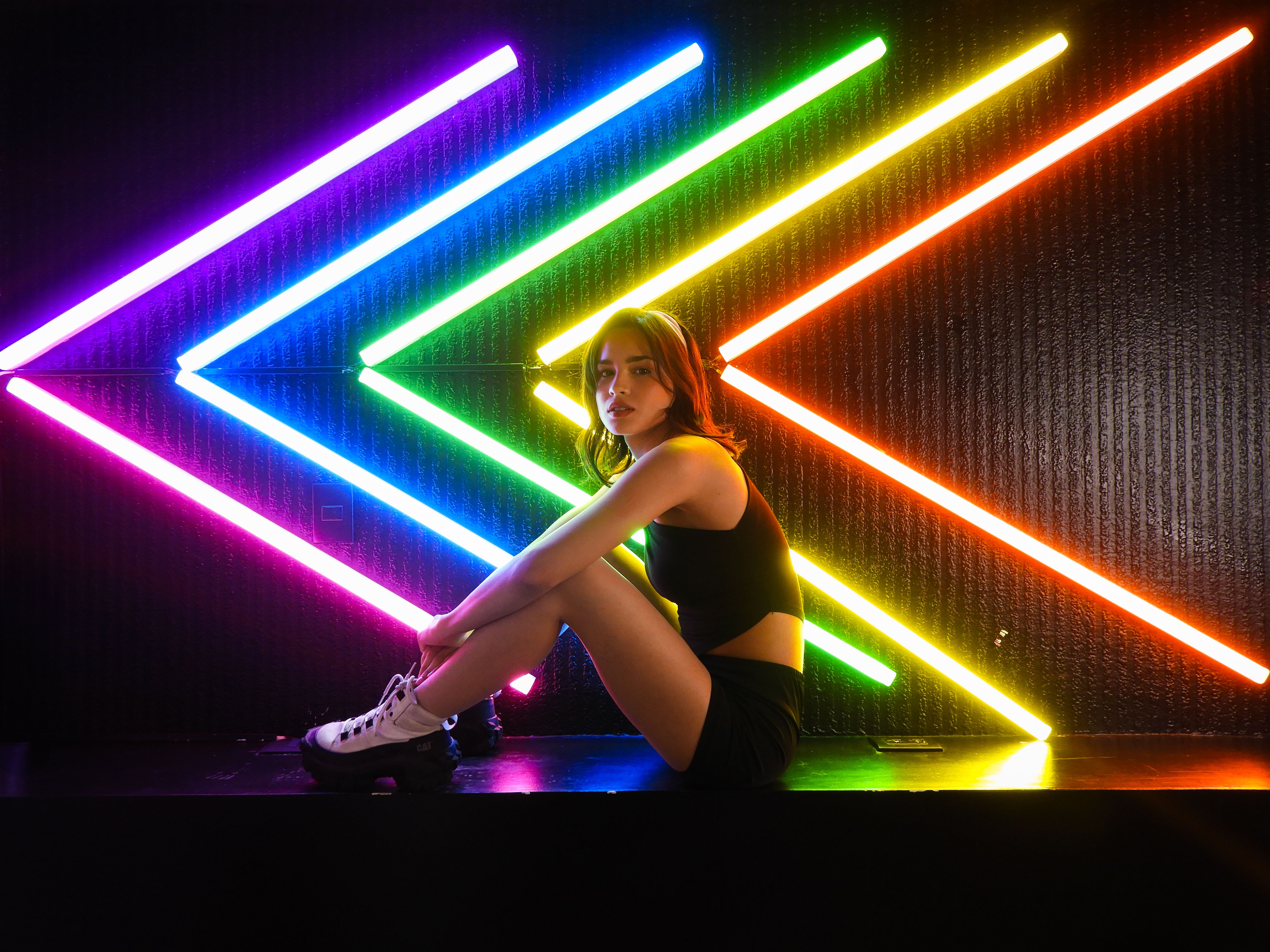 Photo of Woman Posing Next to Neon Sign · Free Stock Photo