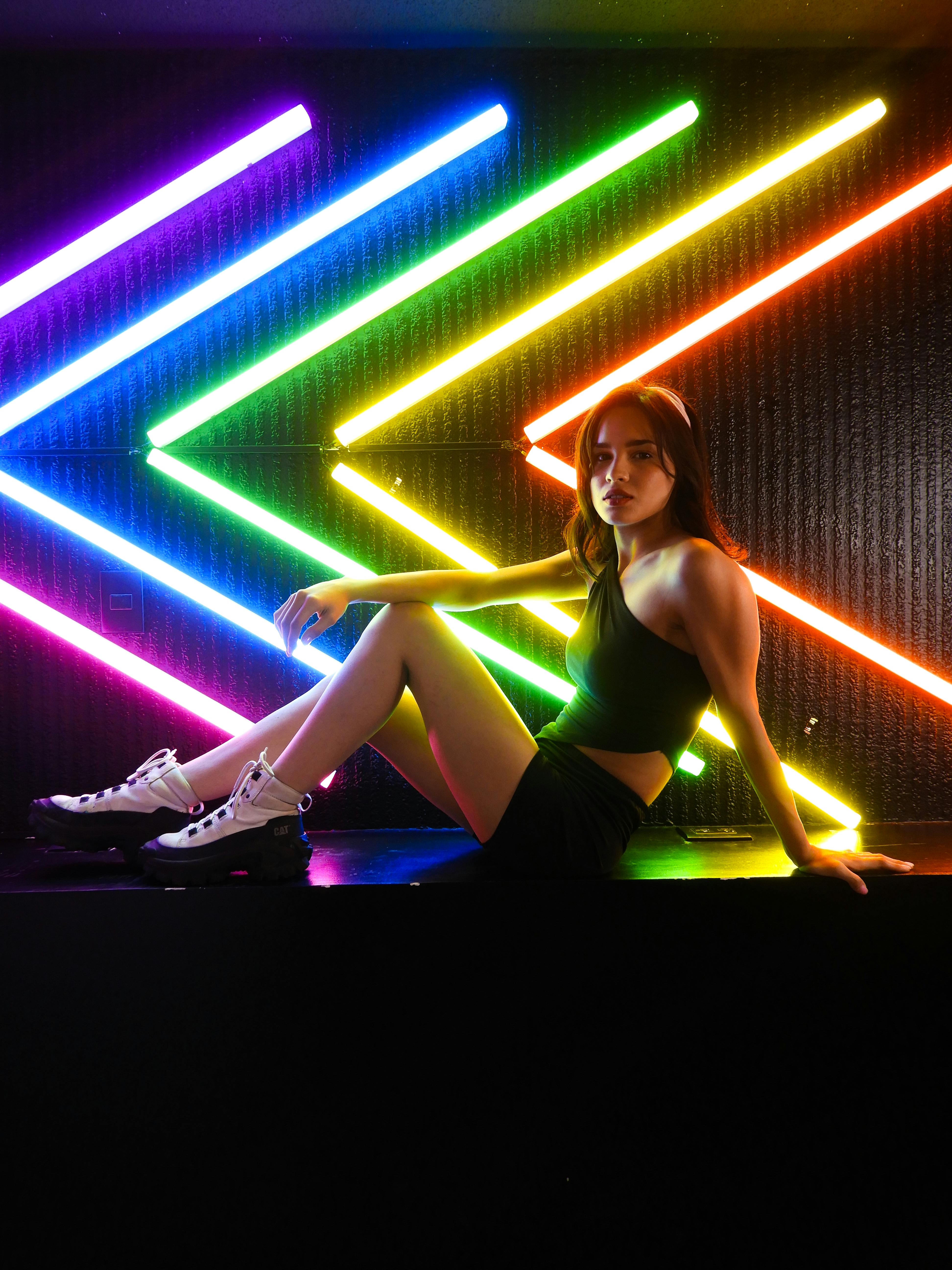 Photo of Woman Posing Next to Neon Sign · Free Stock Photo