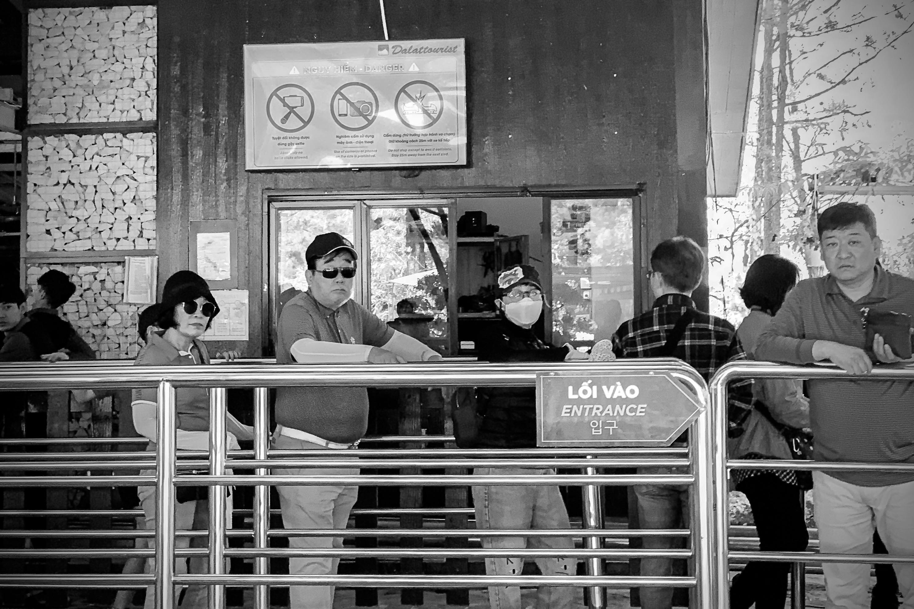 Queue at Entrance with Safety Signage in Black and White · Free Stock Photo