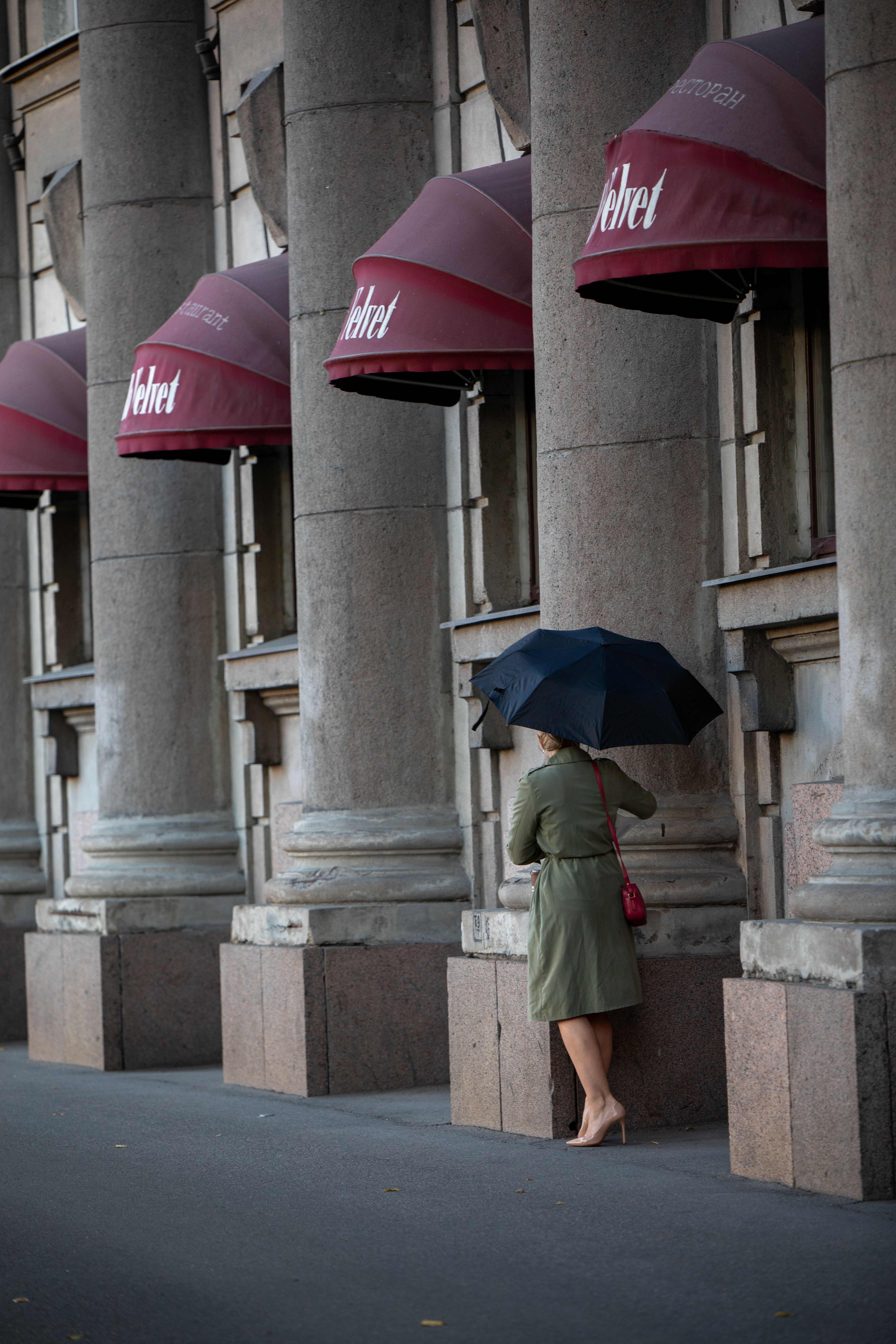 Woman with Umbrella Walking by Columned Building · Free Stock Photo