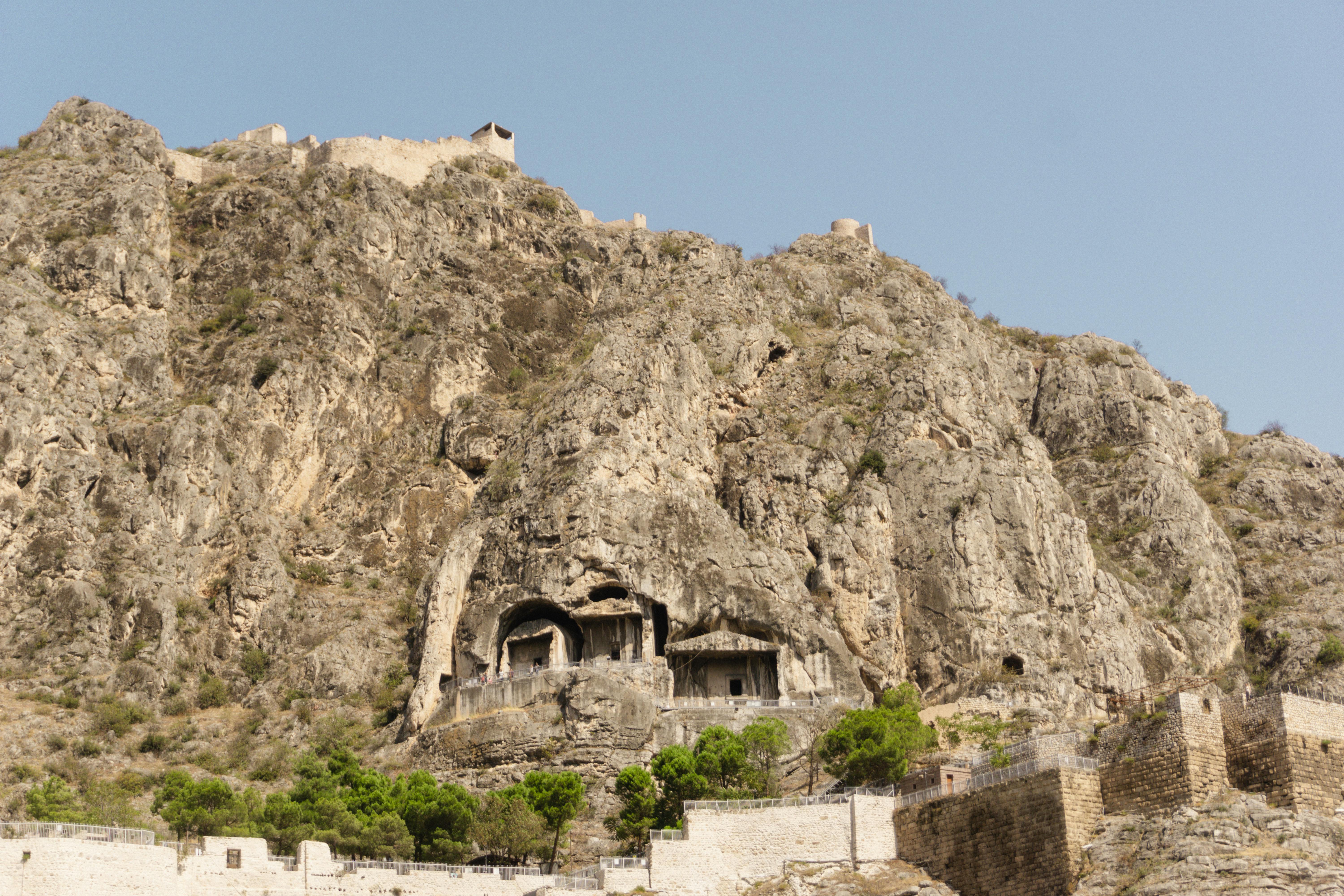 Ancient Rock Tomb with Vegetation in Cliff Face · Free Stock Photo