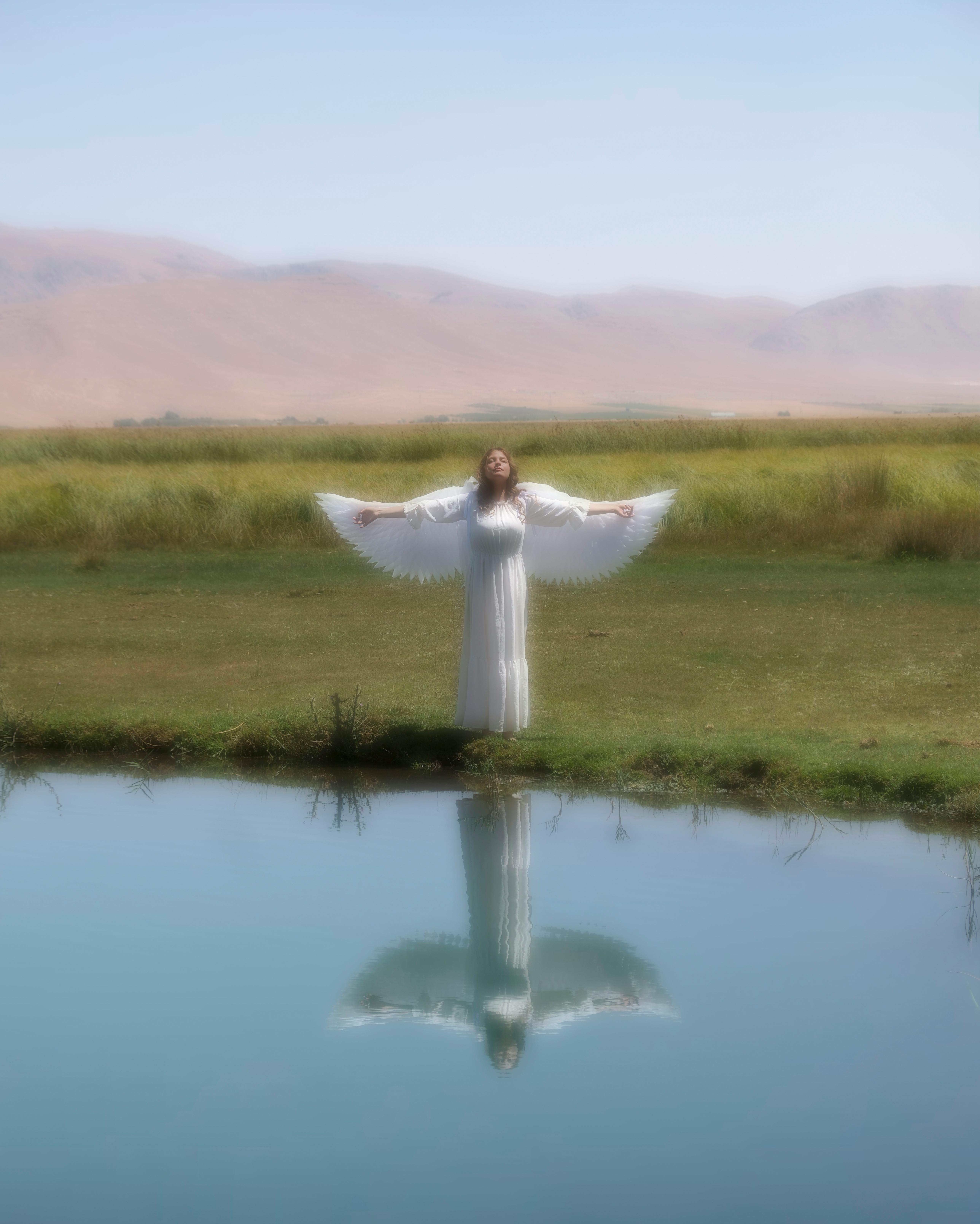 Angel-Like Figure by Reflective Water Scene · Free Stock Photo