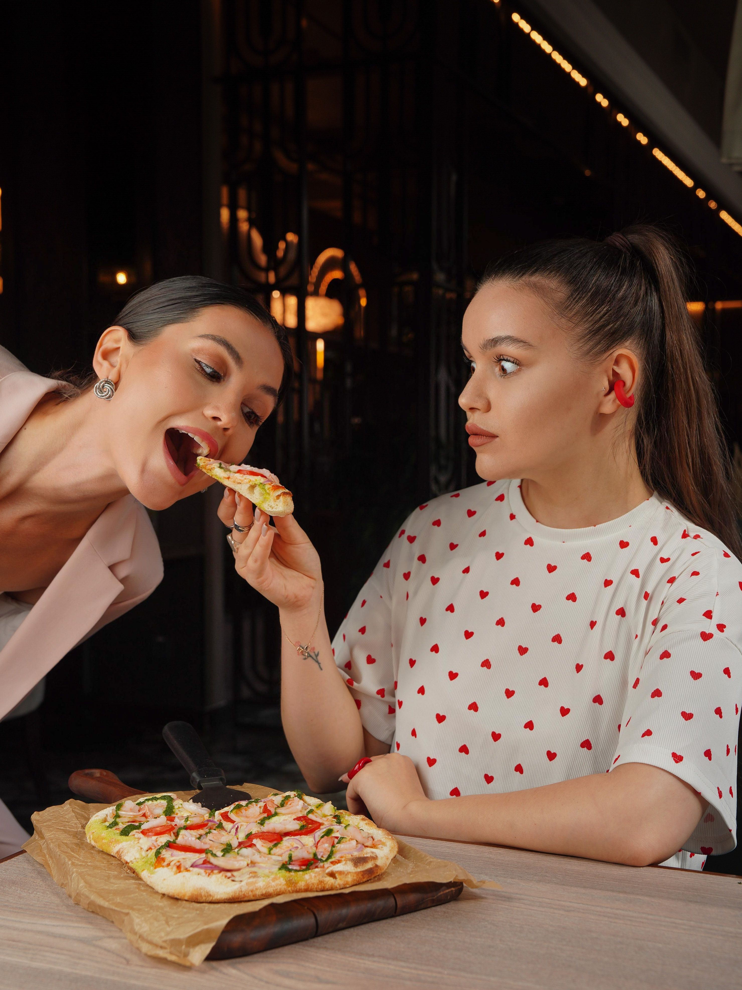 Dos Mujeres Compartiendo Pizza En Un Acogedor Restaurante · Foto de ...