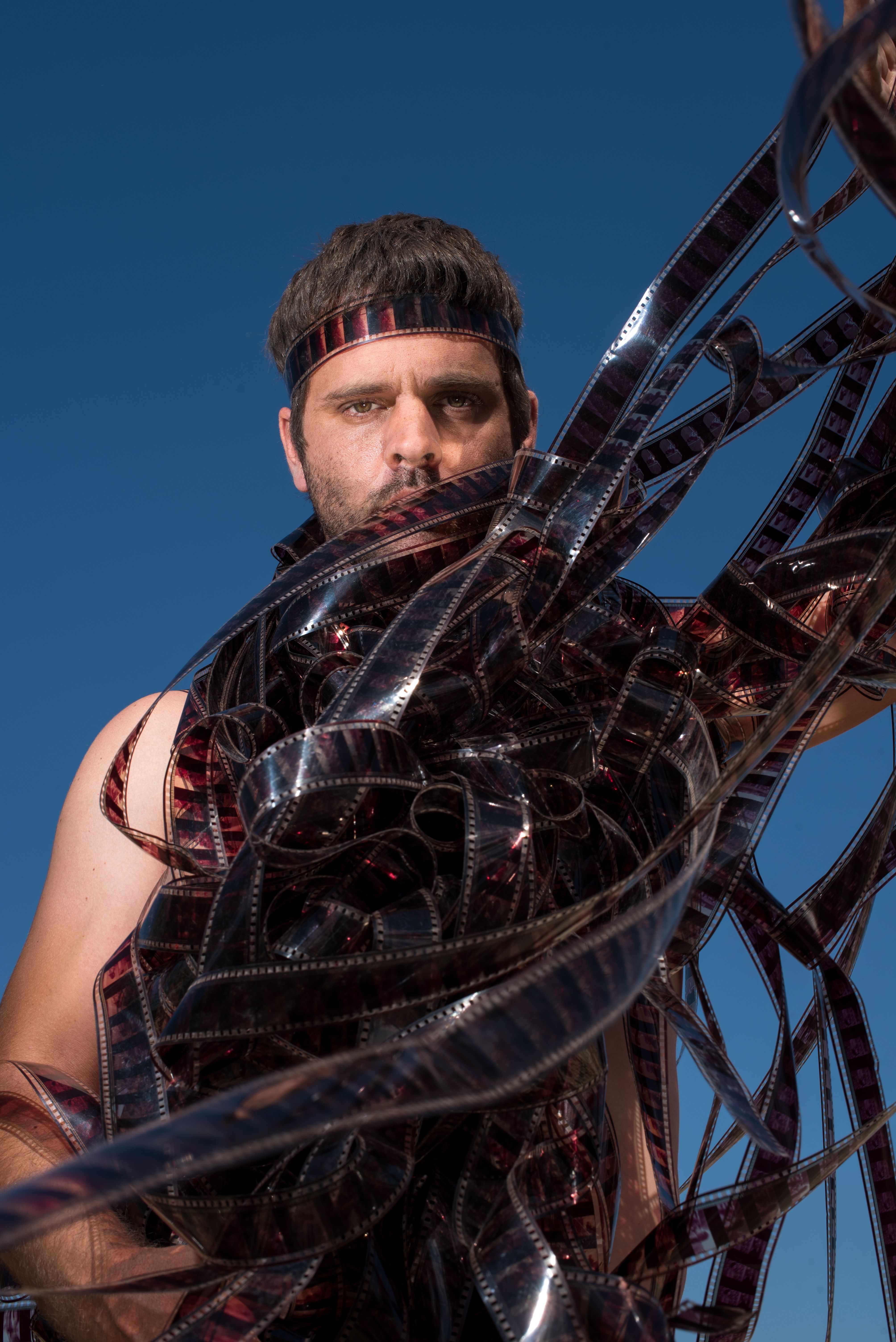 Man Entangled in Vintage Film Strips Outdoors · Free Stock Photo