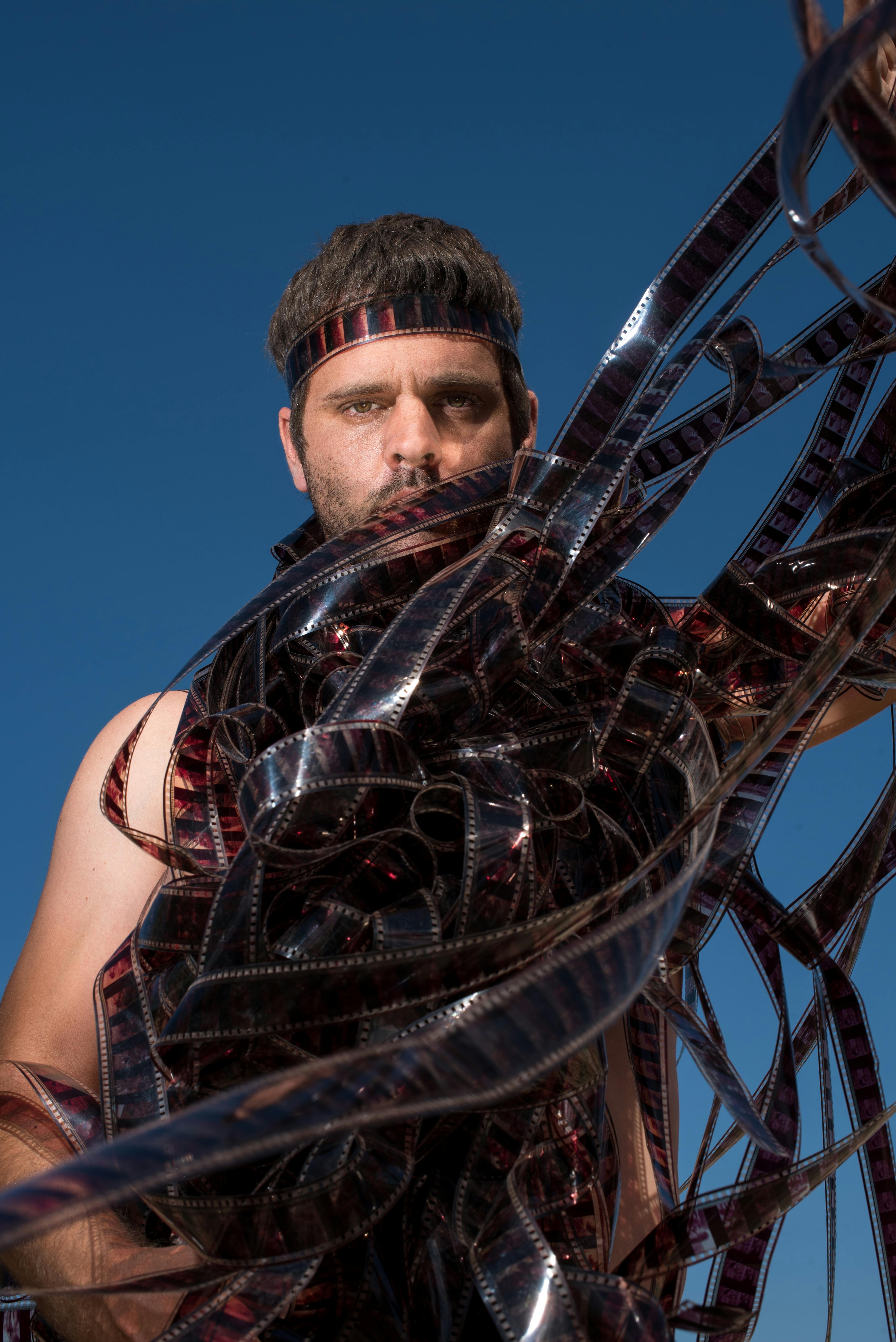 Man Entangled in Vintage Film Strips Outdoors · Free Stock Photo