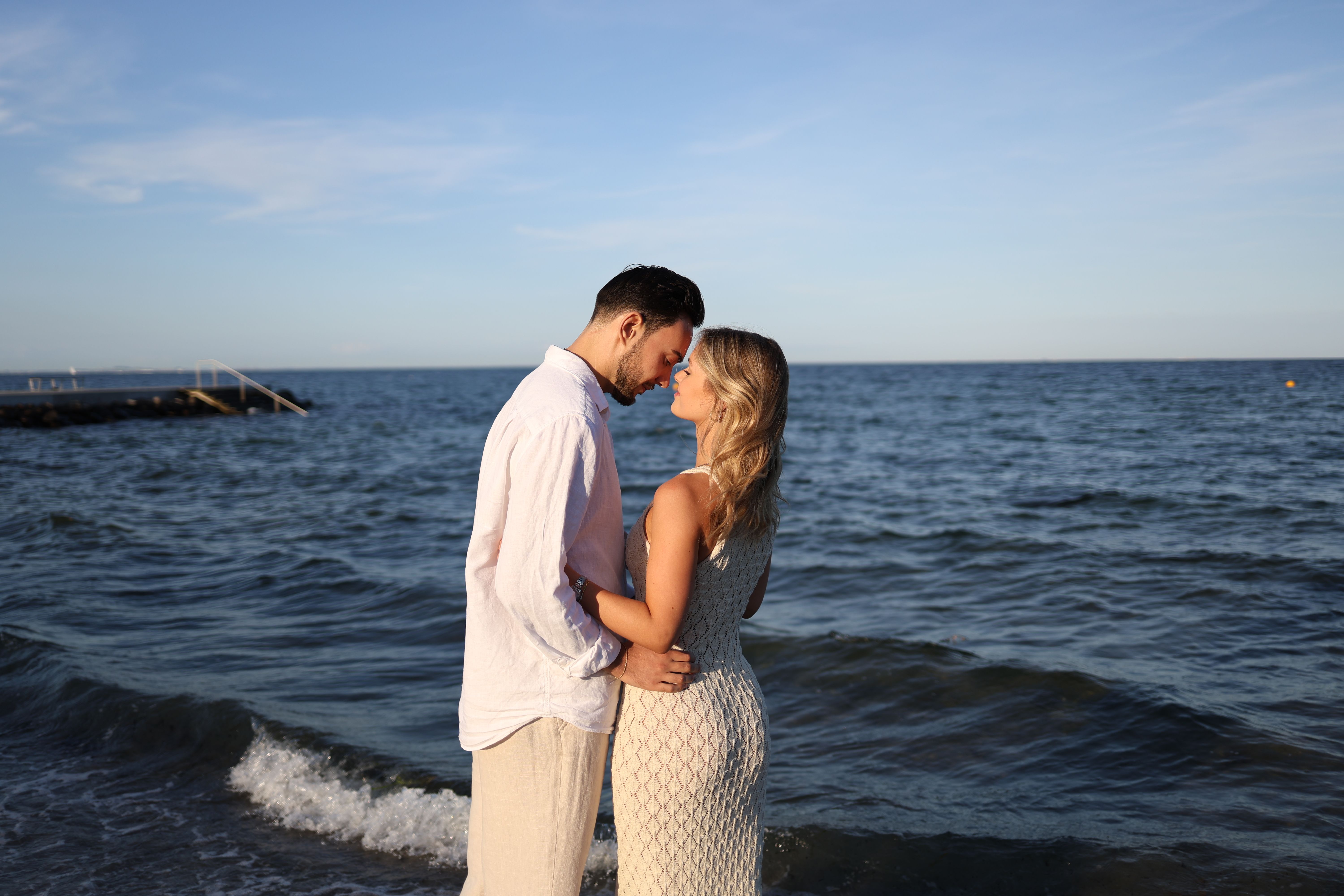 Romantic Couple Embracing by the Ocean at Sunset · Free Stock Photo
