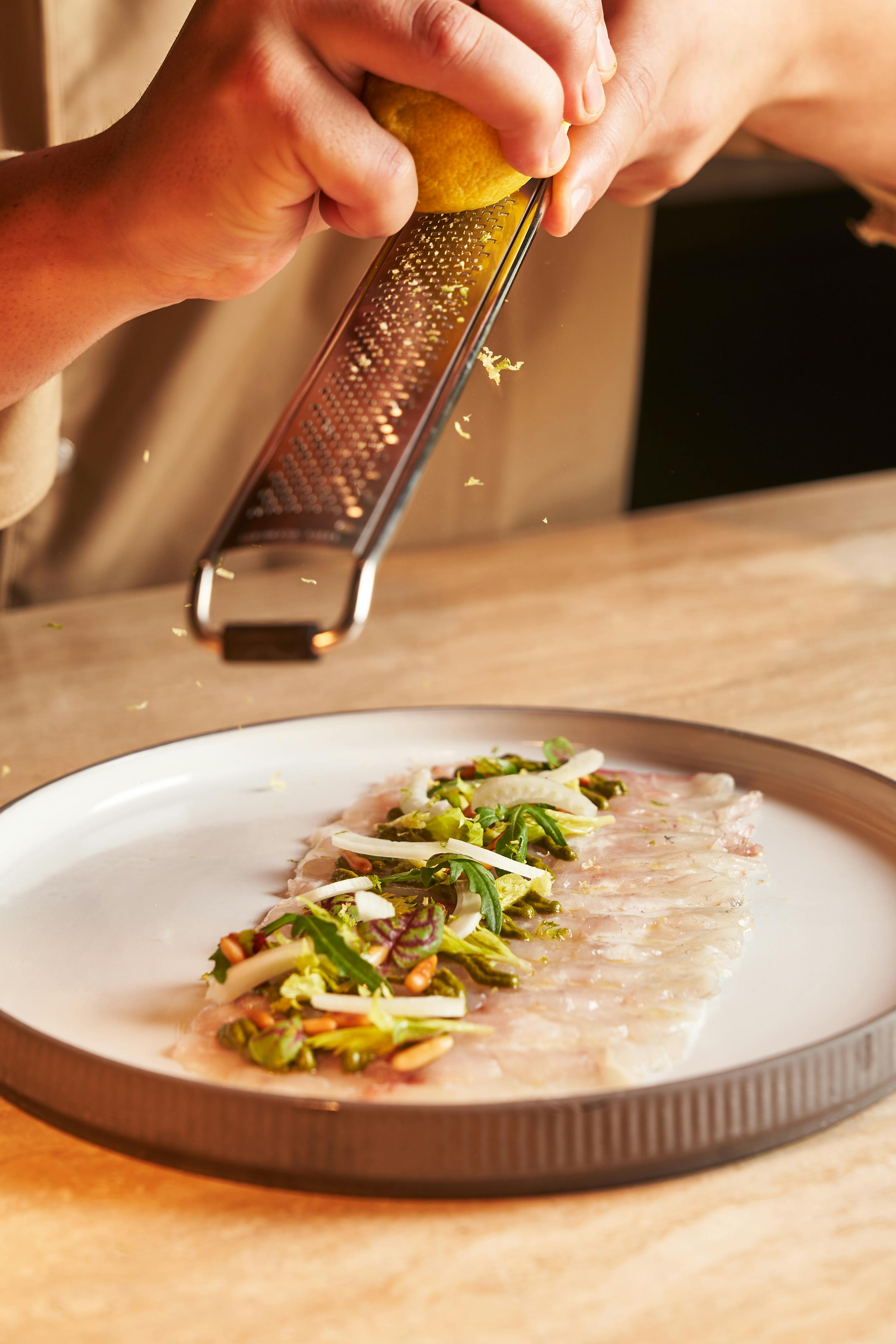 Gourmet Fish Dish with Lemon Zest Preparation · Free Stock Photo