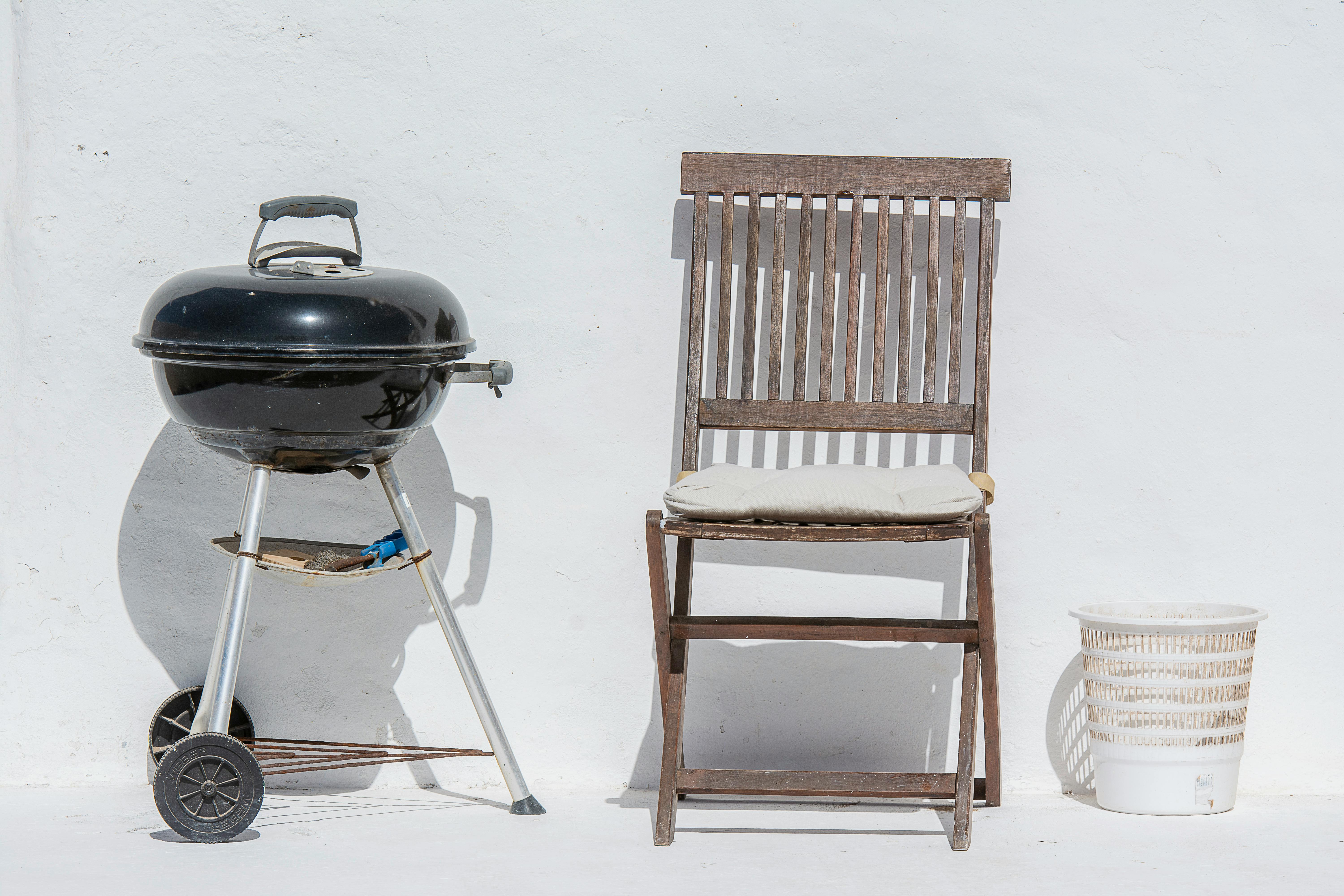 Minimalist Outdoor Barbeque Setup Against White Wall · Free Stock Photo