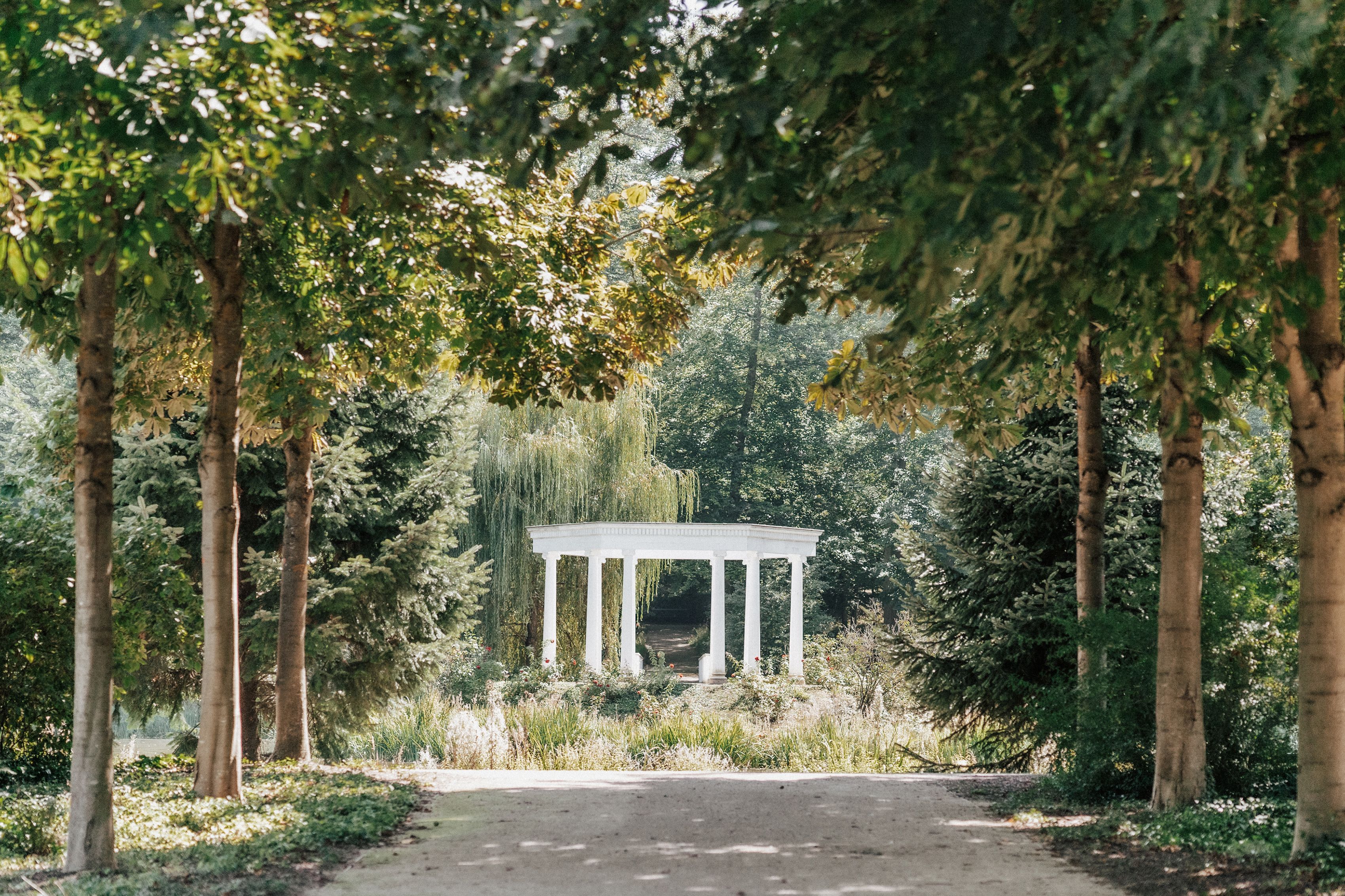 Enchanting Garden Pathway with White Pavilion · Free Stock Photo