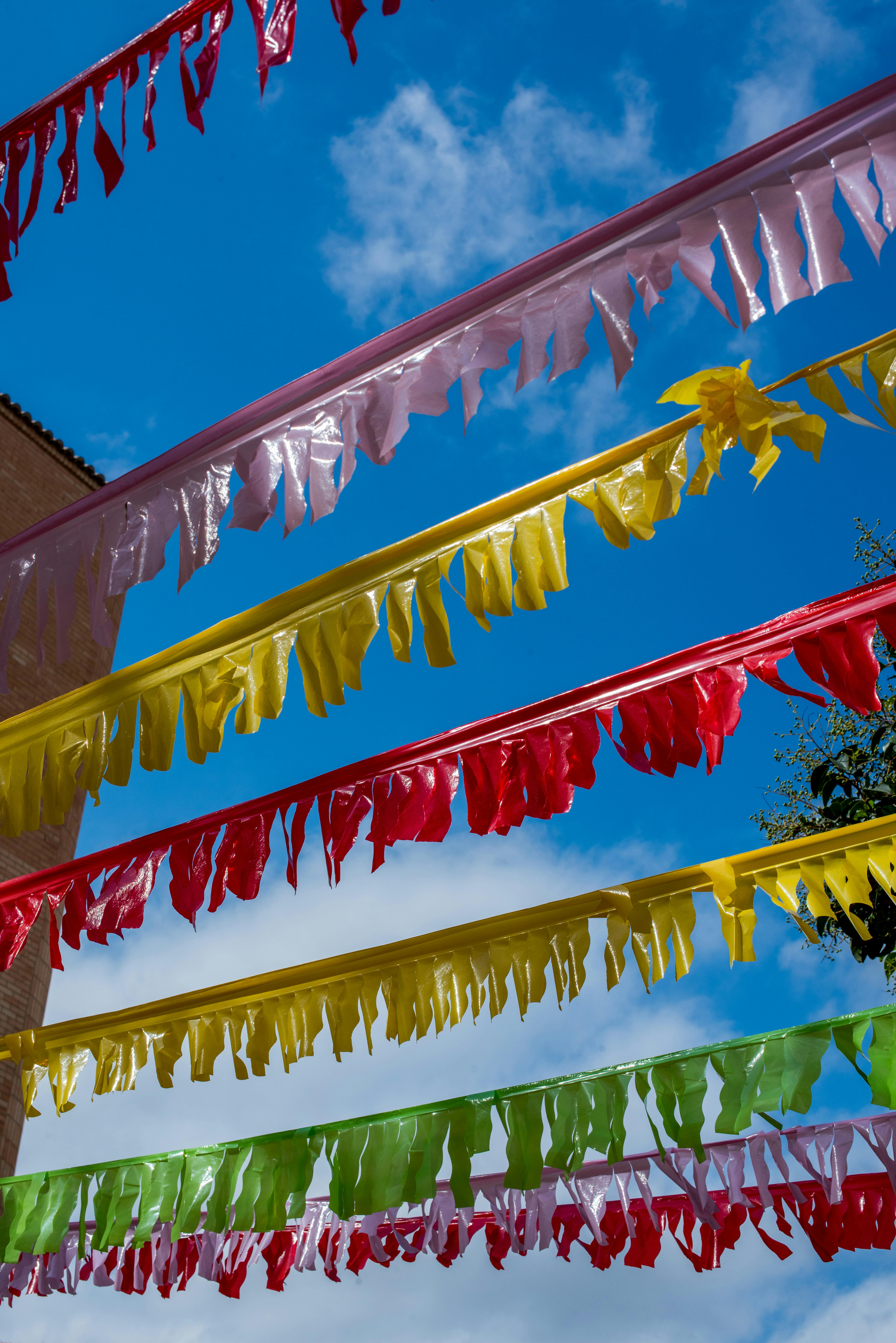 Colorful Street Festival Banners Against Blue Sky · Free Stock Photo