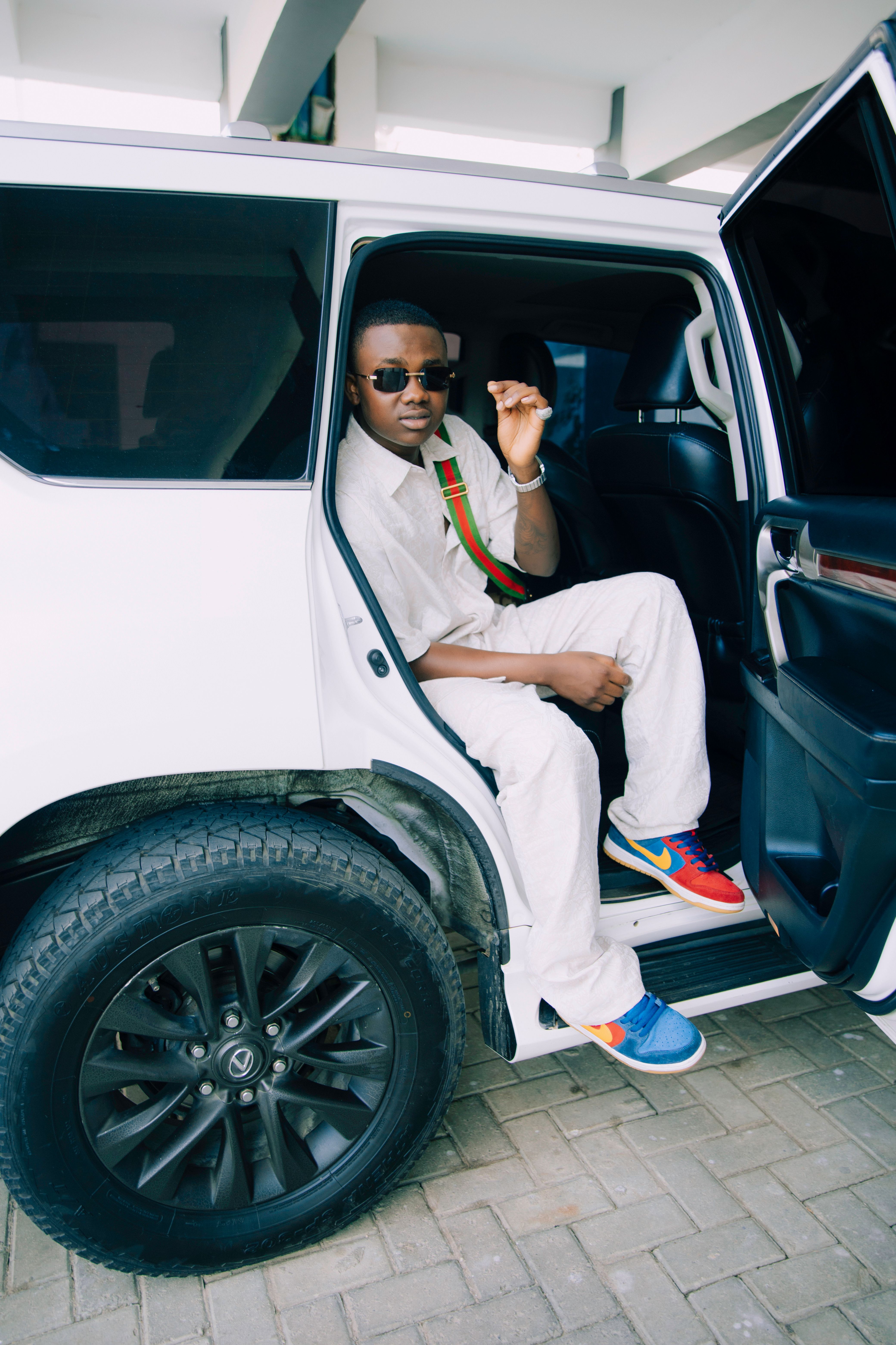 Stylish man stepping out of luxury vehicle · Free Stock Photo