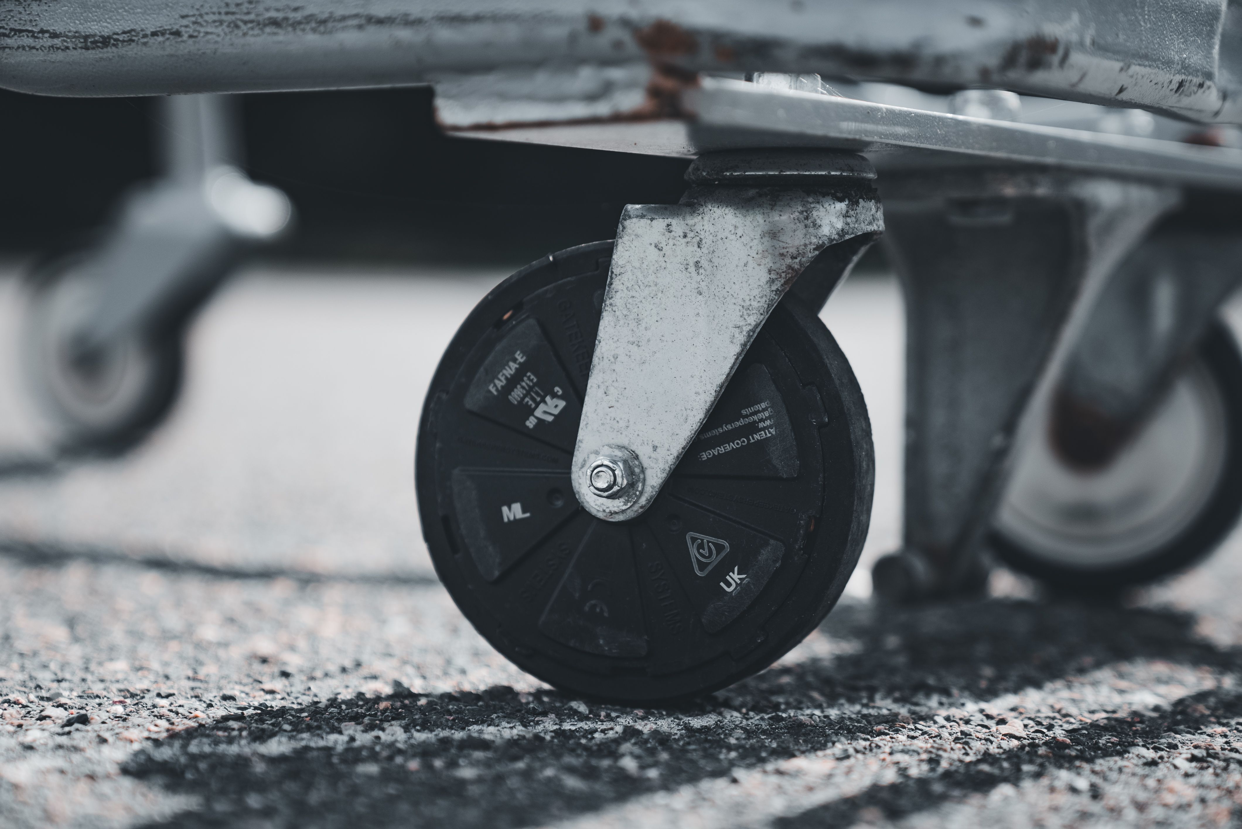 Close-up of a shopping cart wheel on pavement · Free Stock Photo