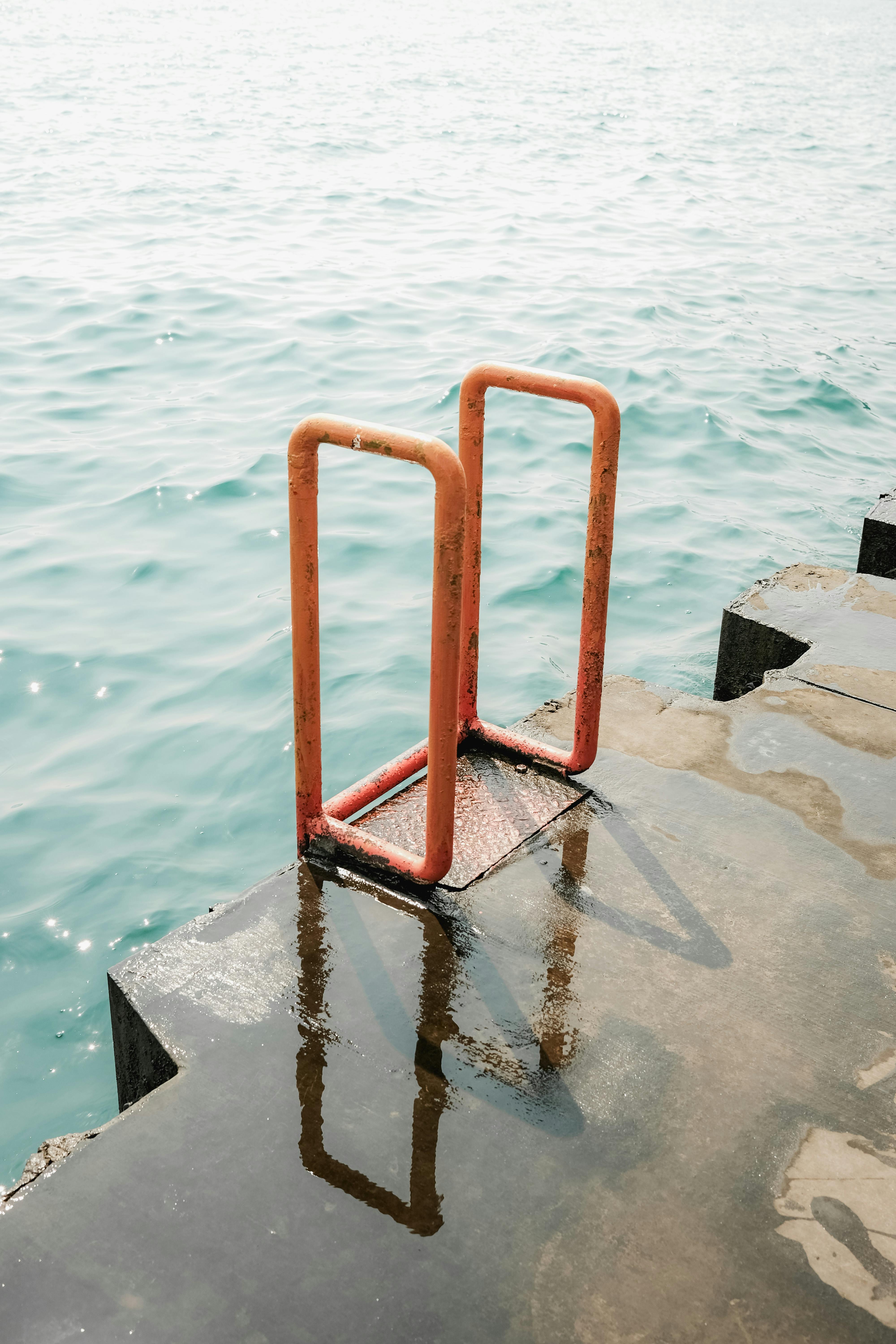 Vibrant Orange Lakefront Ladder Reflection · Free Stock Photo