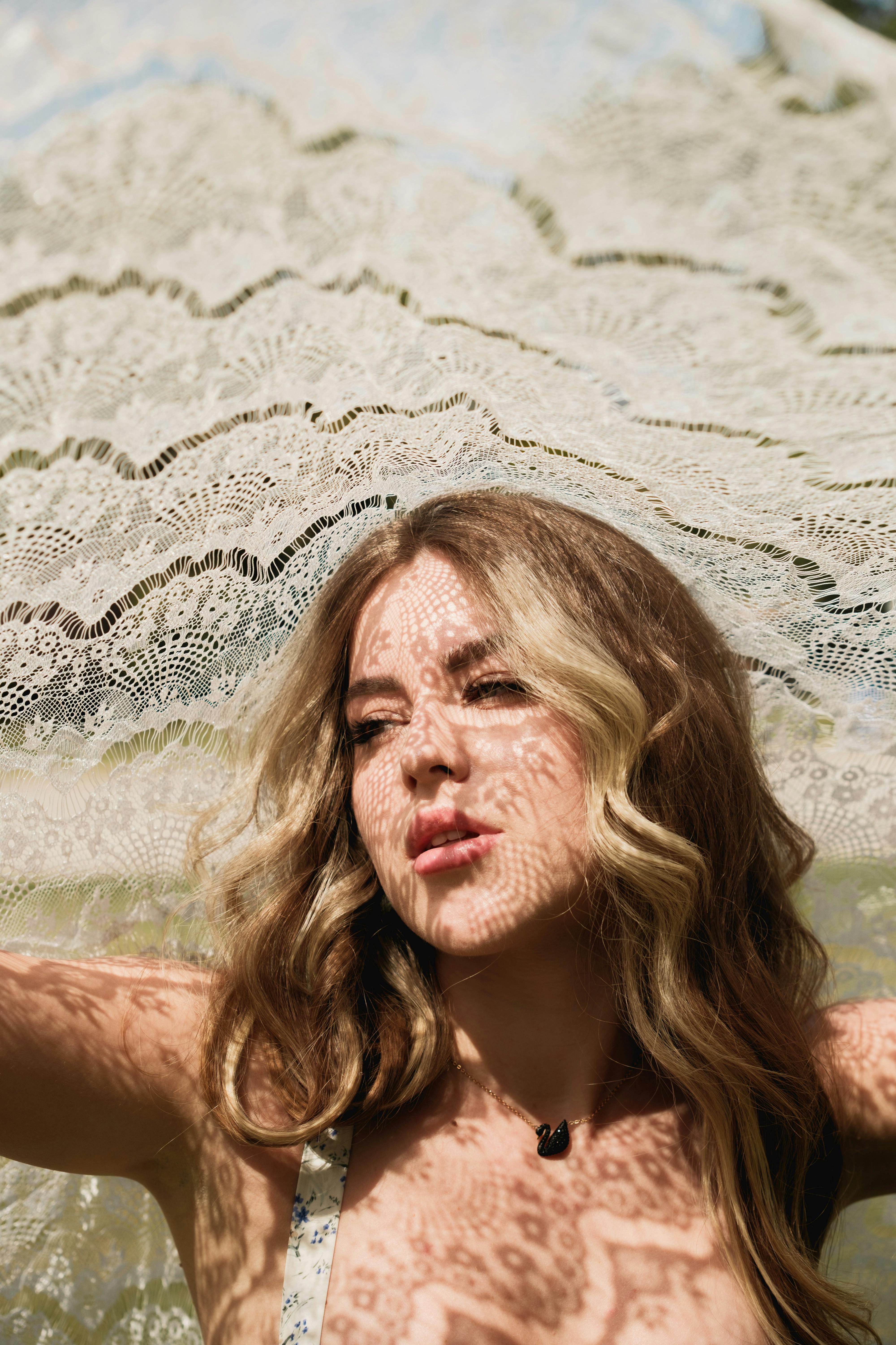 Portrait of Woman with Lace Shadow Pattern Outdoors · Free Stock Photo