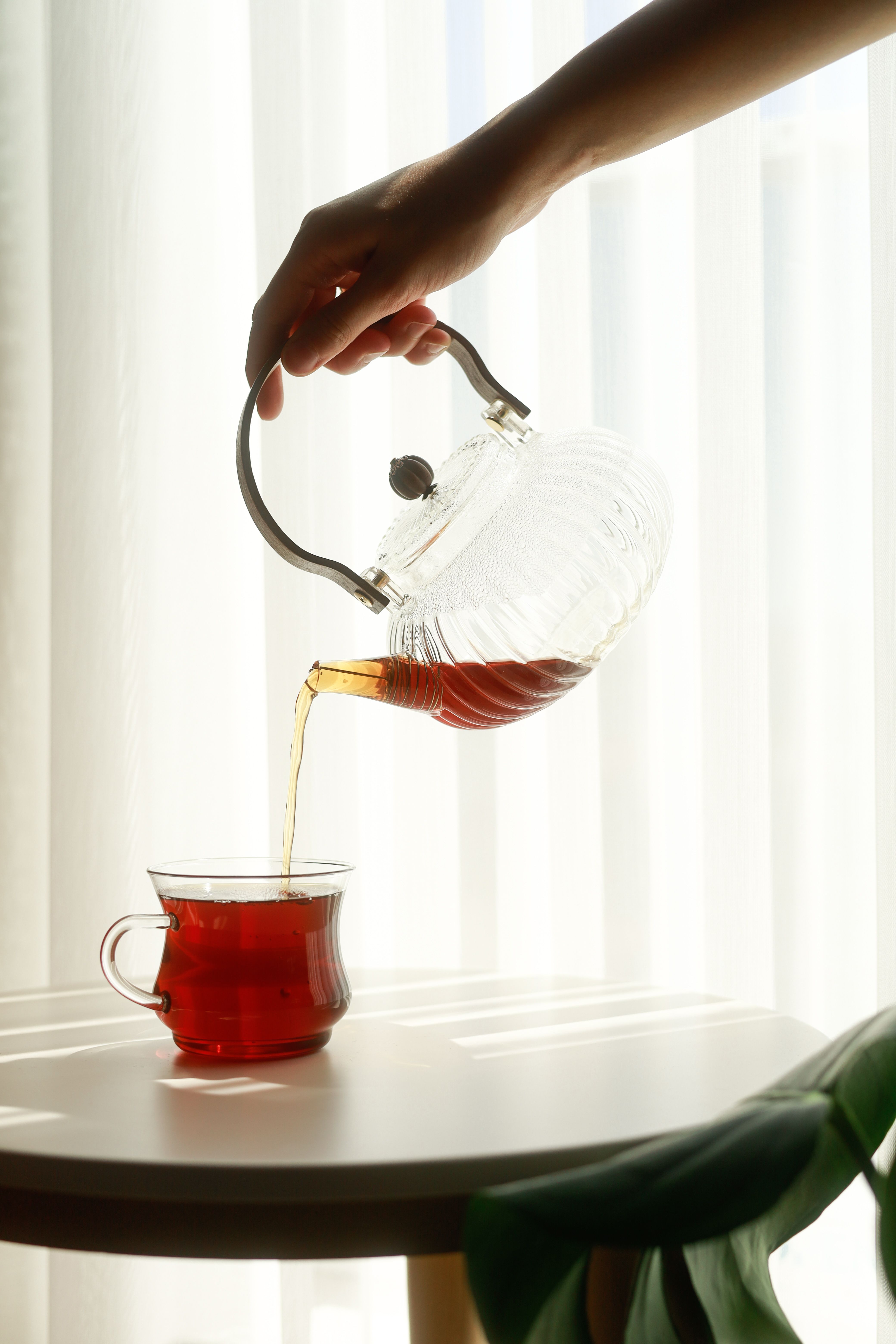 Pouring Tea from Glass Teapot into Cup · Free Stock Photo