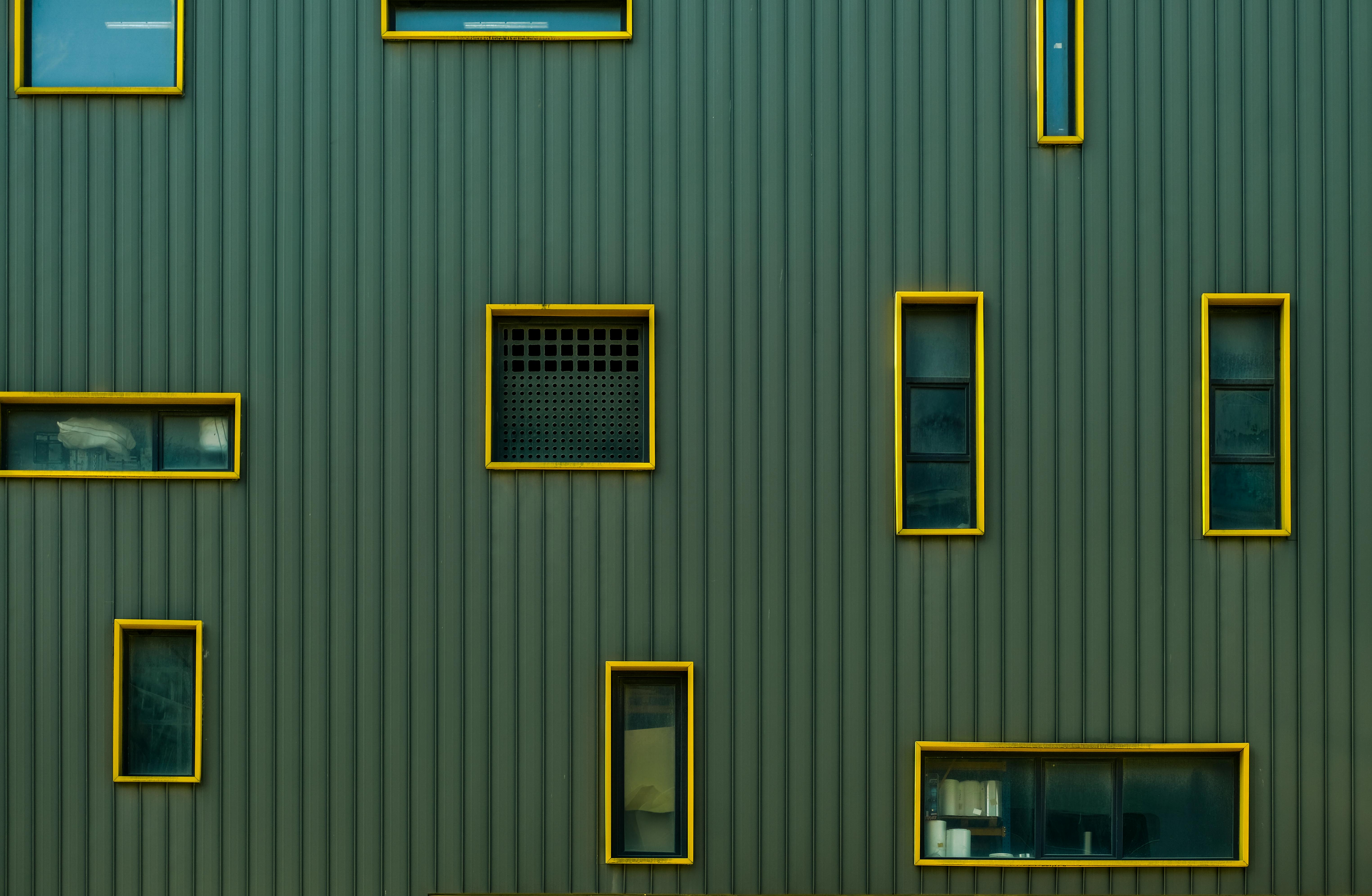 Modern Architectural Facade with Geometric Windows · Free Stock Photo