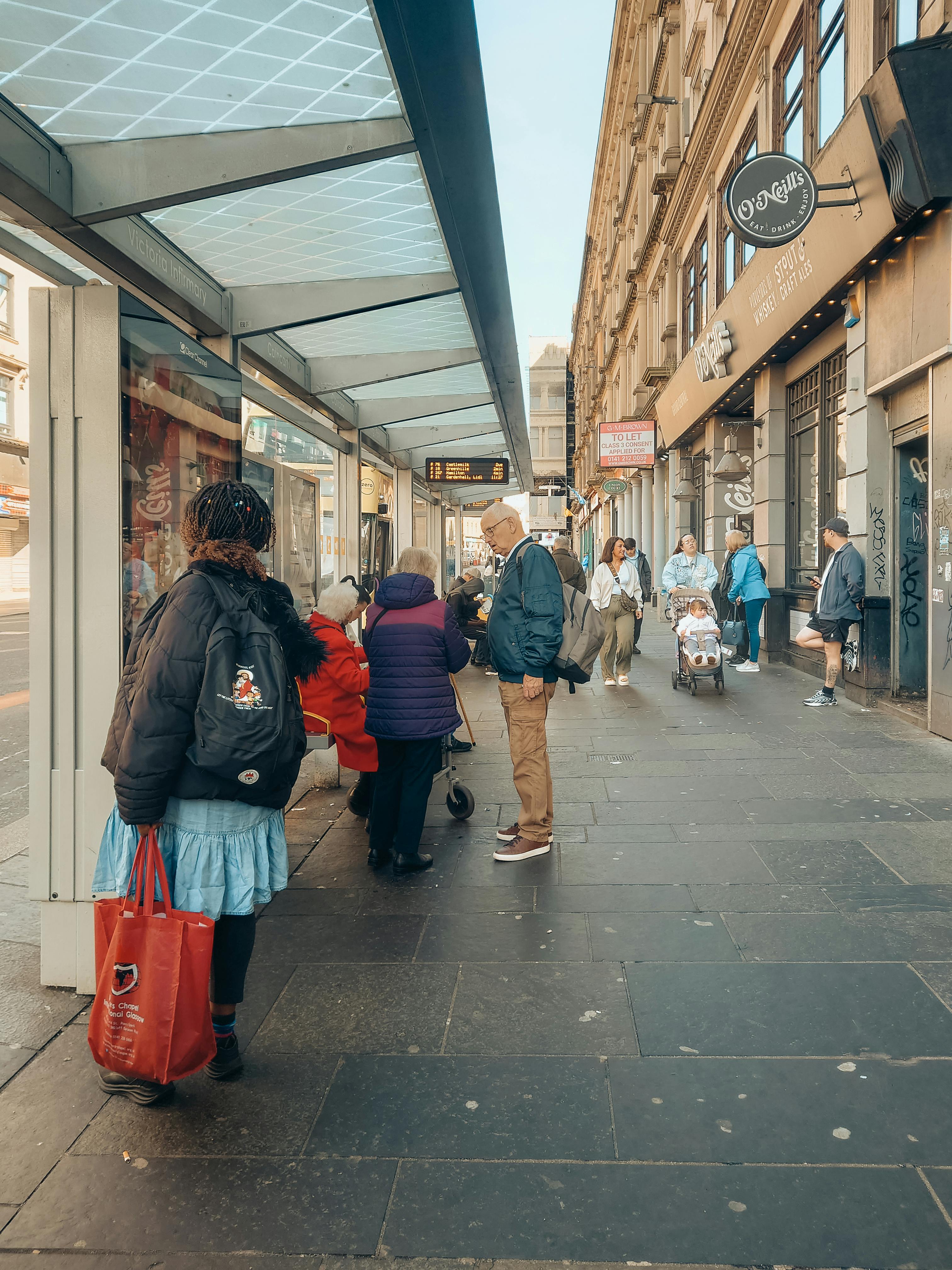 Urban street scene at a busy bus stop · Free Stock Photo
