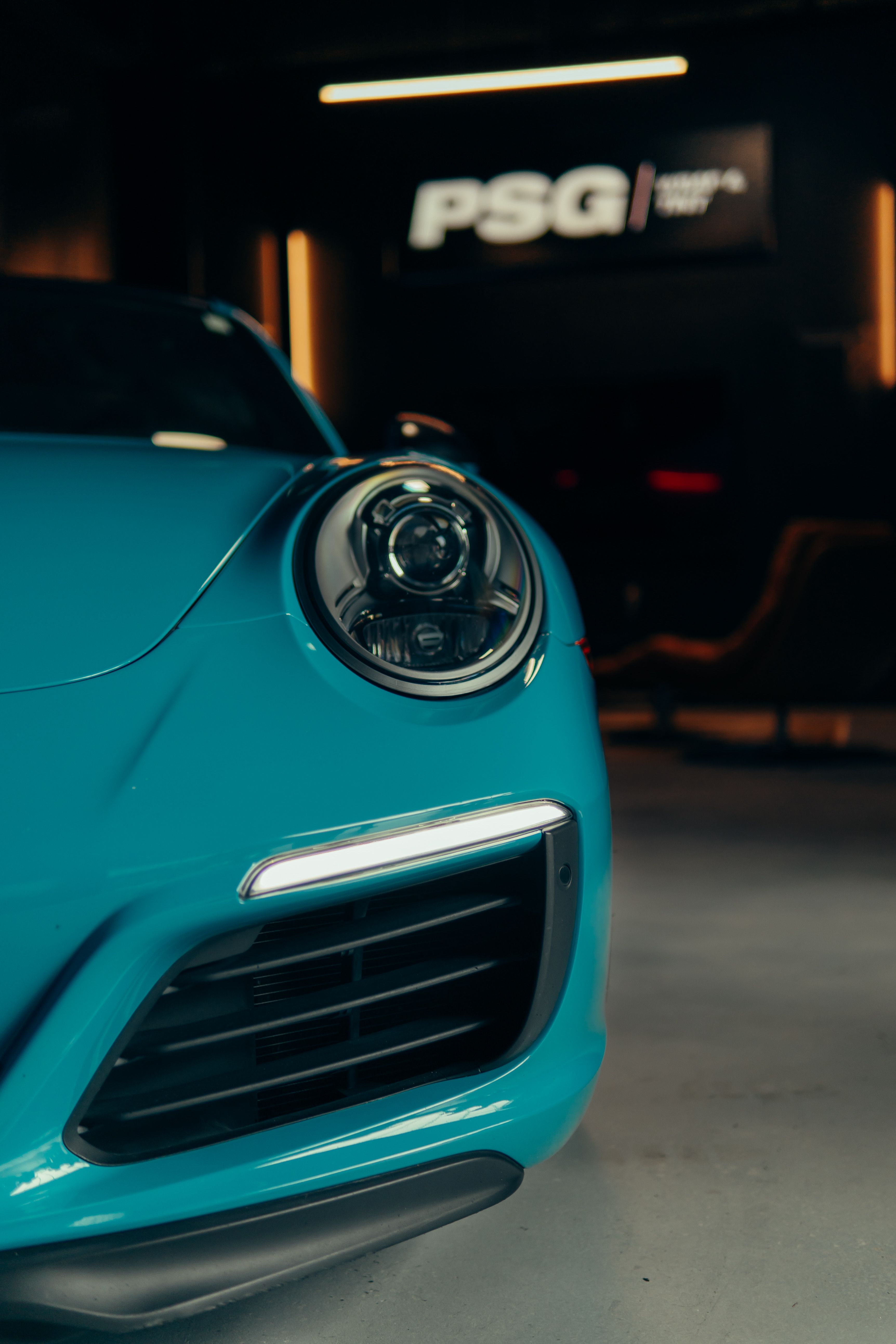 Close-Up of Turquoise Sports Car in Garage · Free Stock Photo