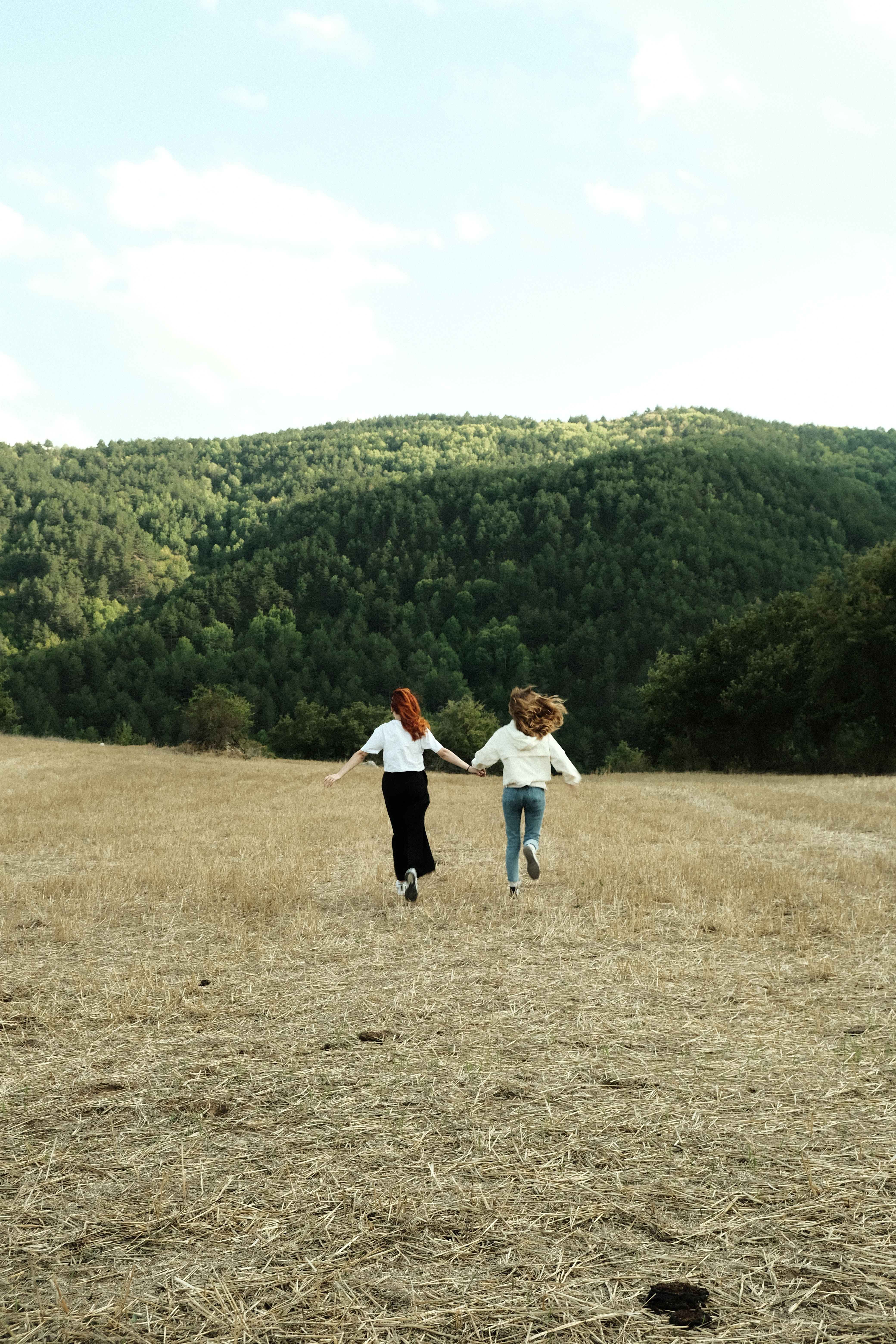 Two Women Running Through Scenic Field · Free Stock Photo
