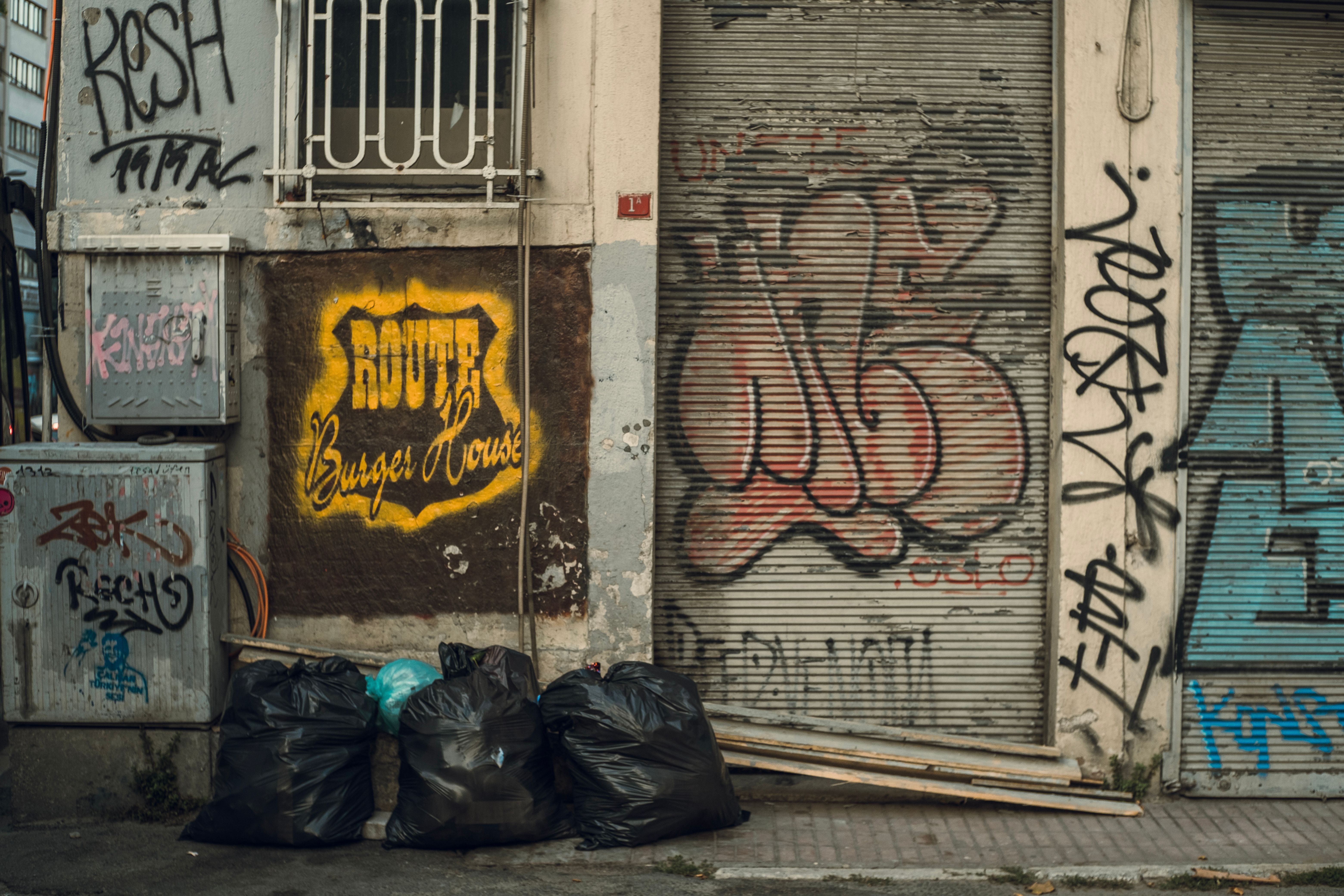 Urban Street Scene with Graffiti and Trash Bags · Free Stock Photo