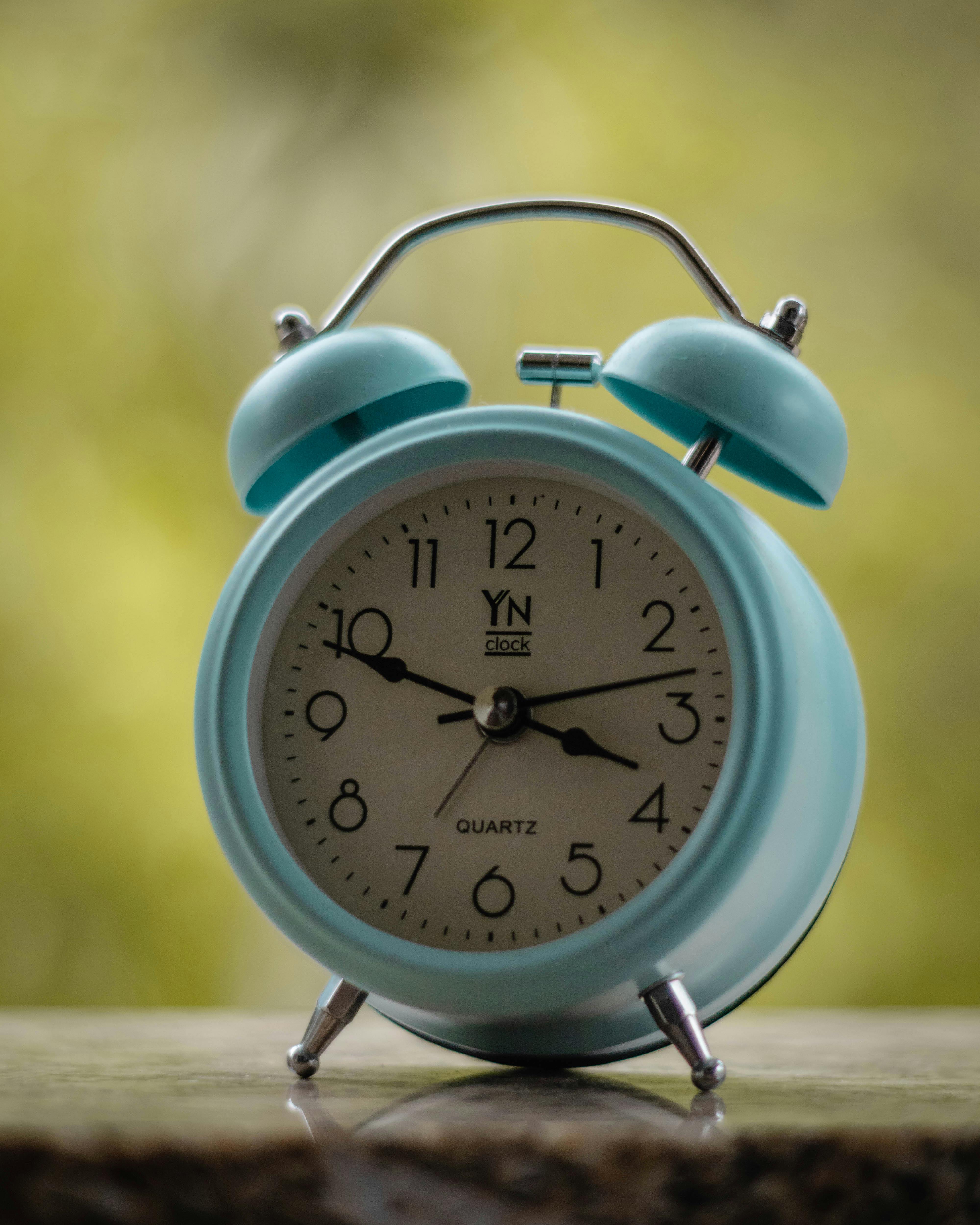 Vintage Blue Alarm Clock on Reflective Surface · Free Stock Photo