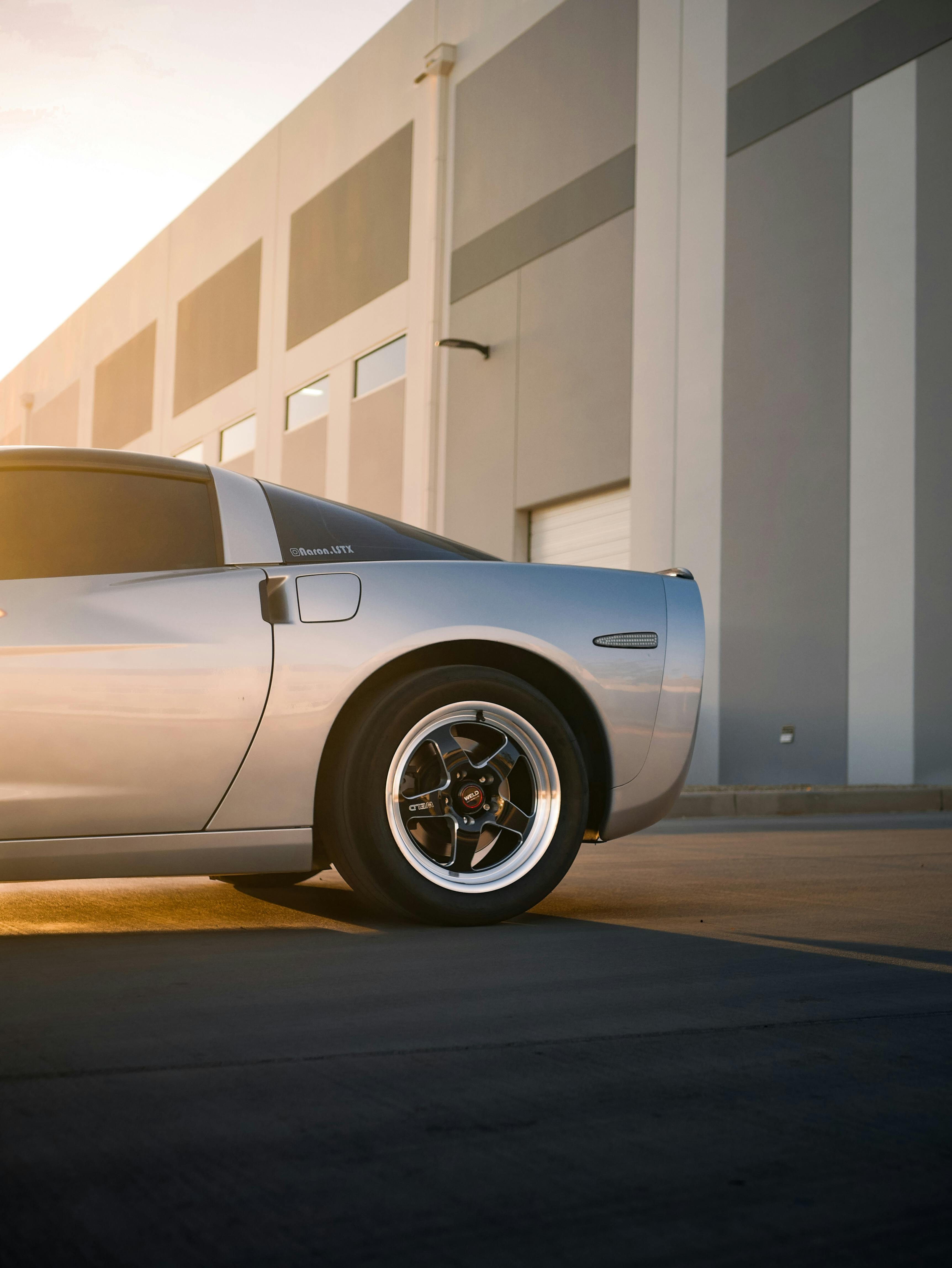 Sleek Rear View of Silver Sports Car at Sunset · Free Stock Photo