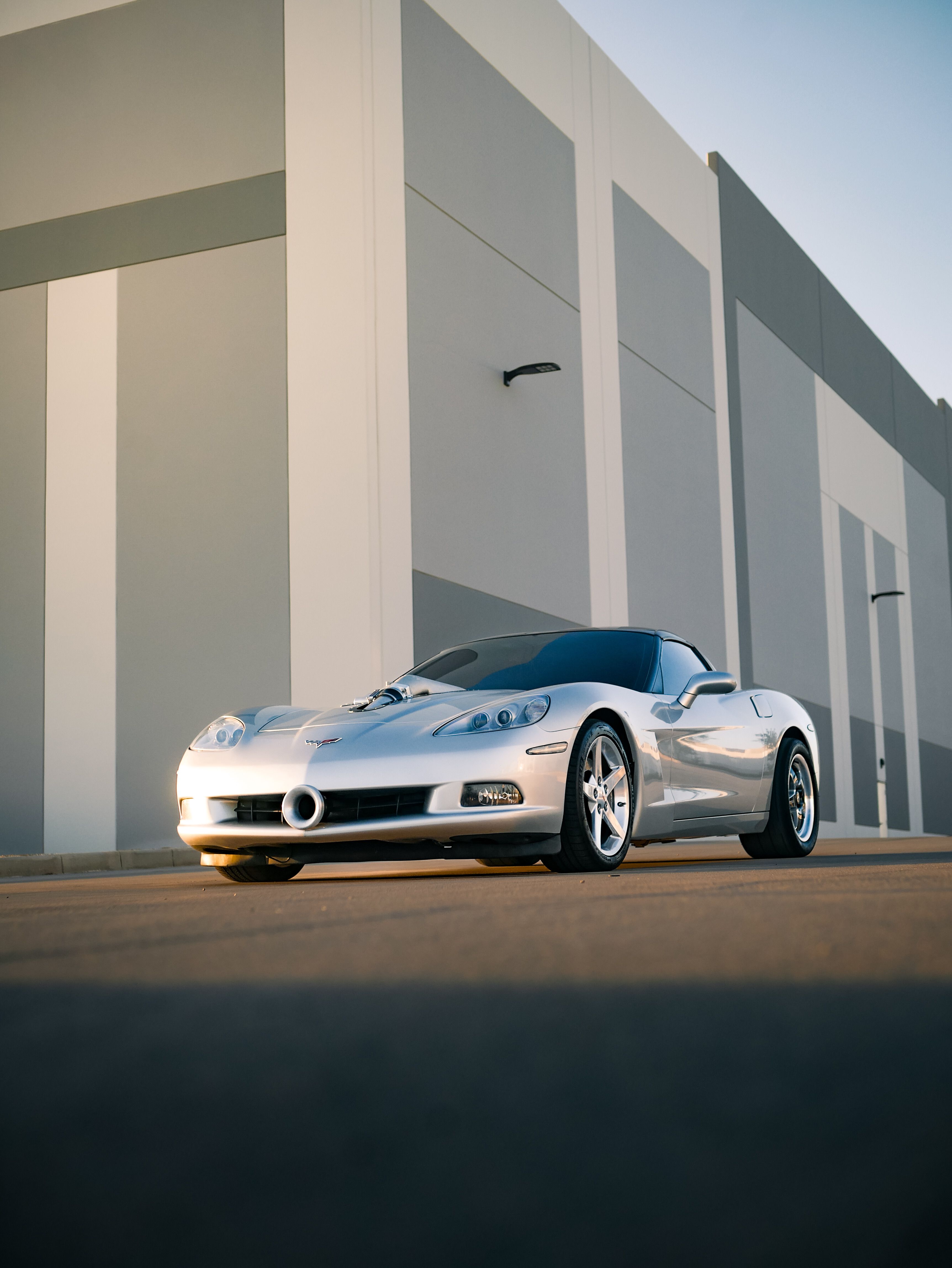 Luxury Silver Sports Car in Modern Urban Setting · Free Stock Photo