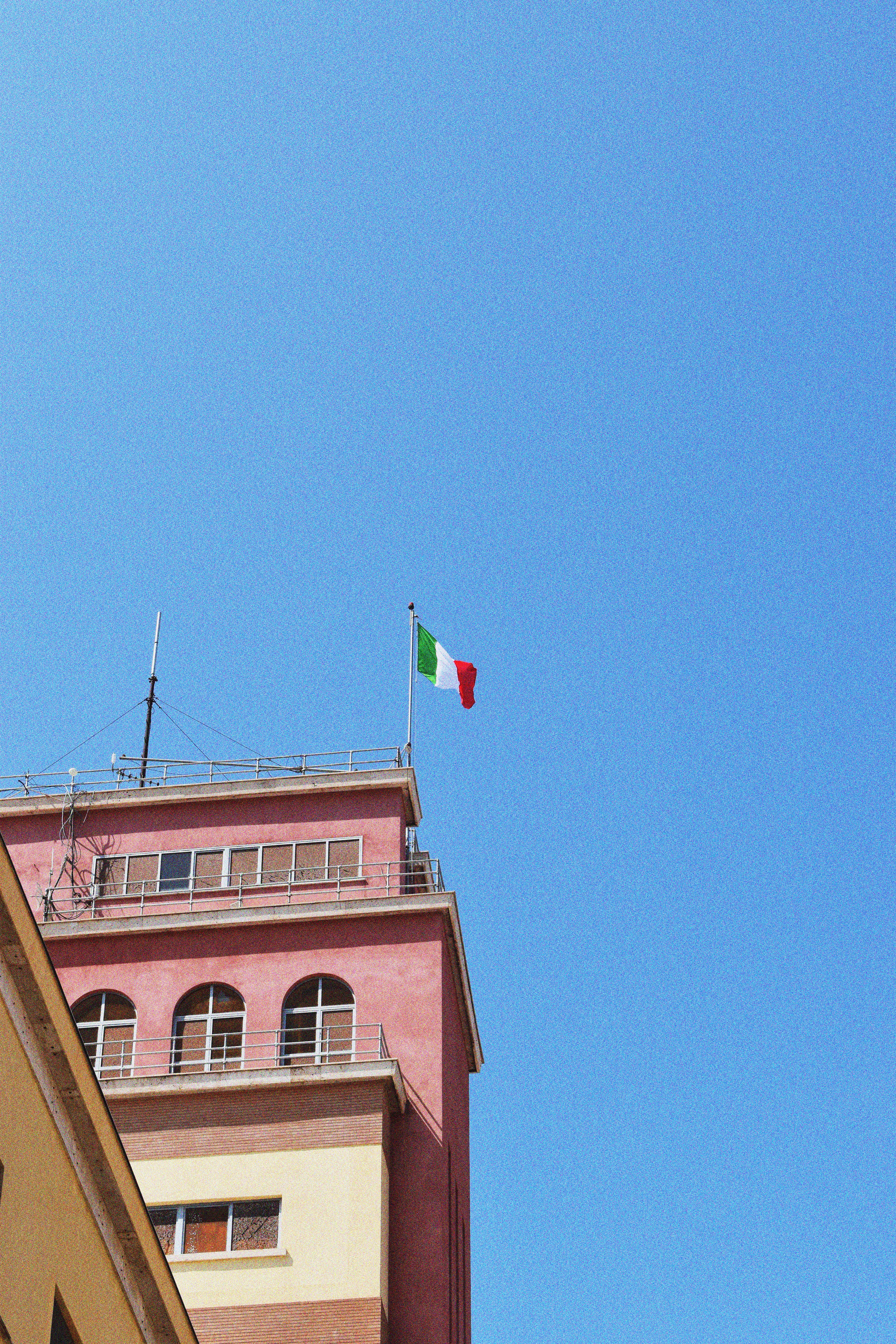 Italian Flag on Urban Building Rooftop · Free Stock Photo