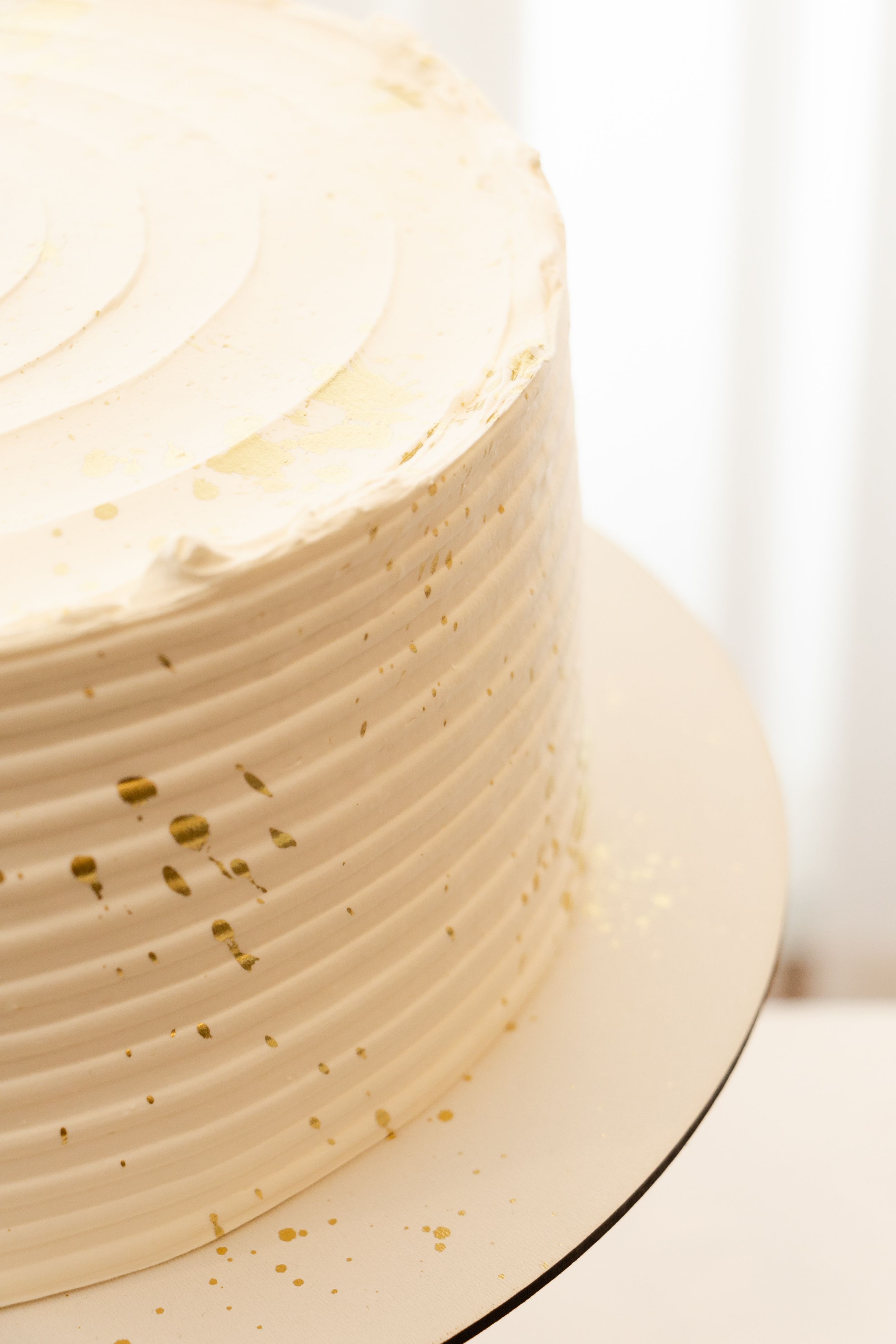 Close-Up of Elegant White Cake with Gold Accents · Free Stock Photo