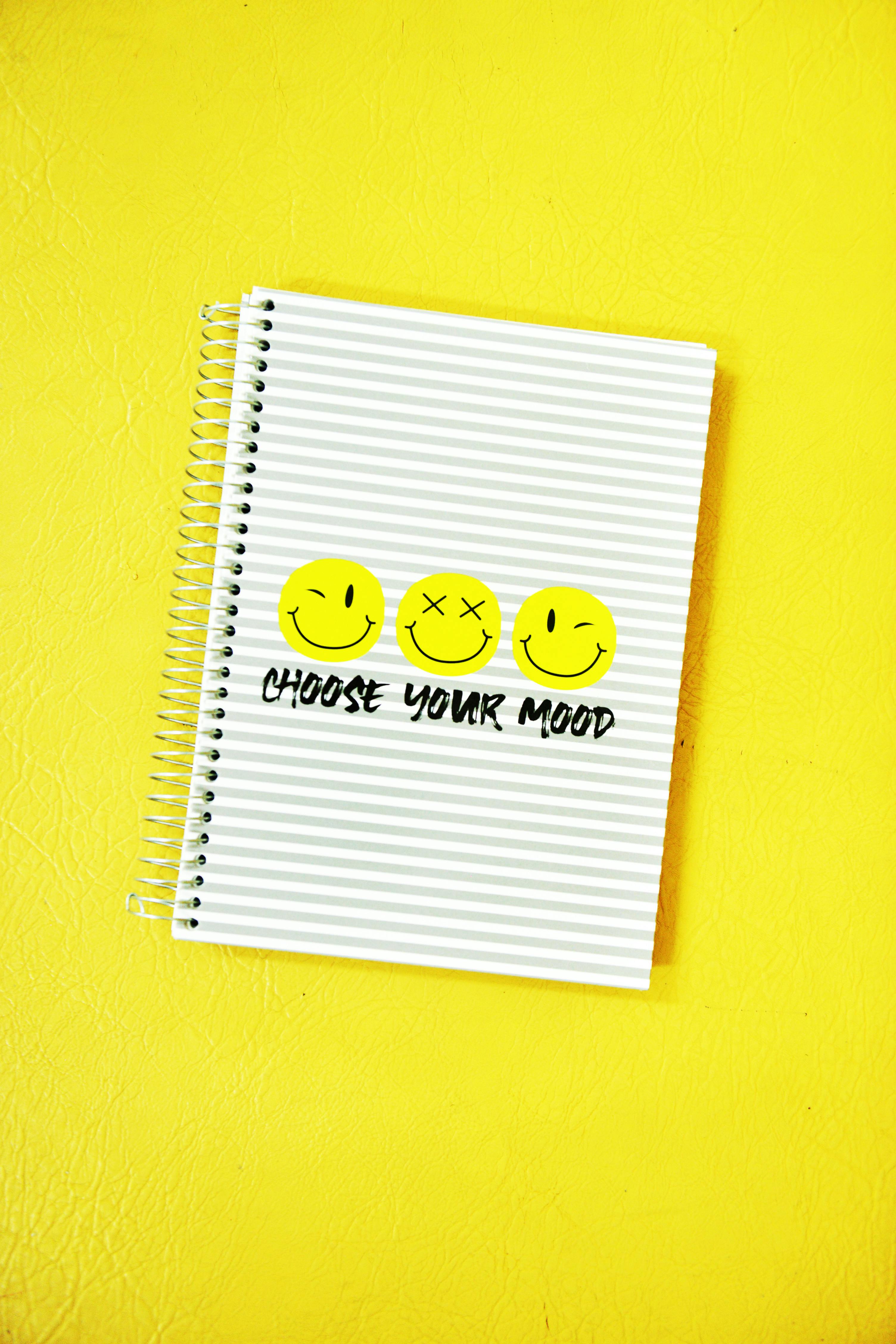 Bright Notebook with Mood Smiley Faces on Yellow · Free Stock Photo
