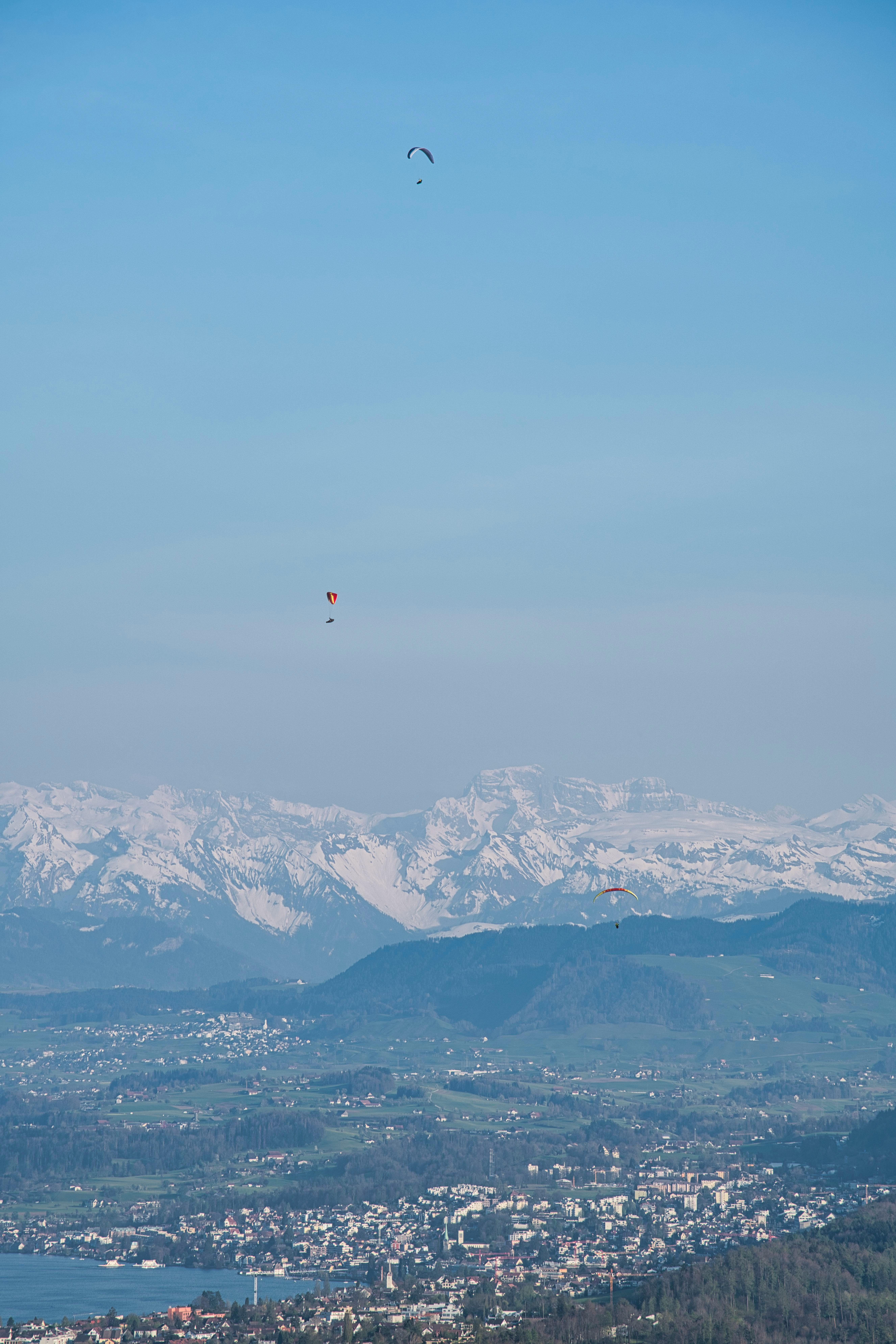 Aerial View of Snowy Swiss Alps with Paragliders · Free Stock Photo