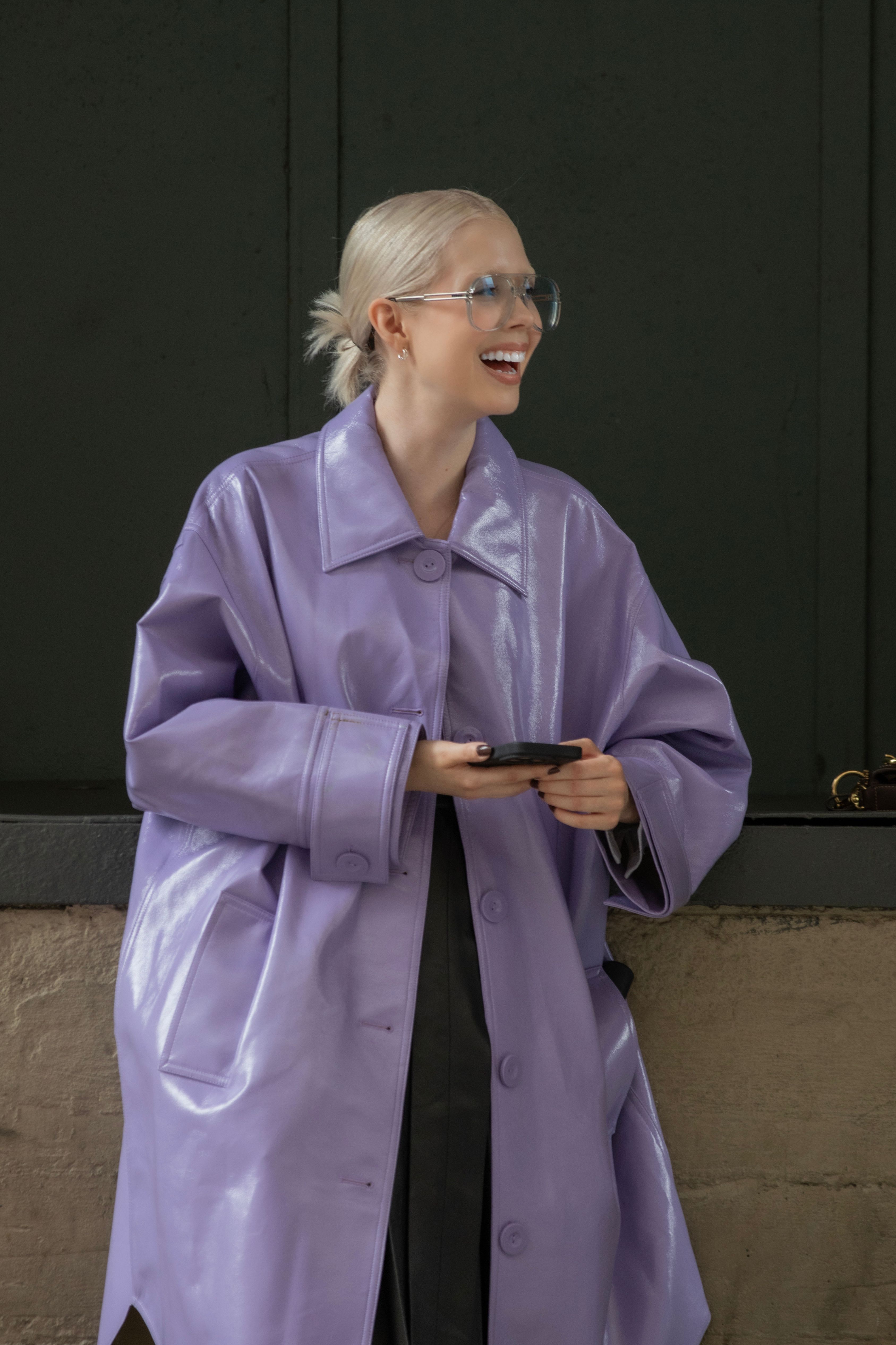 Fashionable Woman in Lavender Coat Smiling Outdoors · Free Stock Photo
