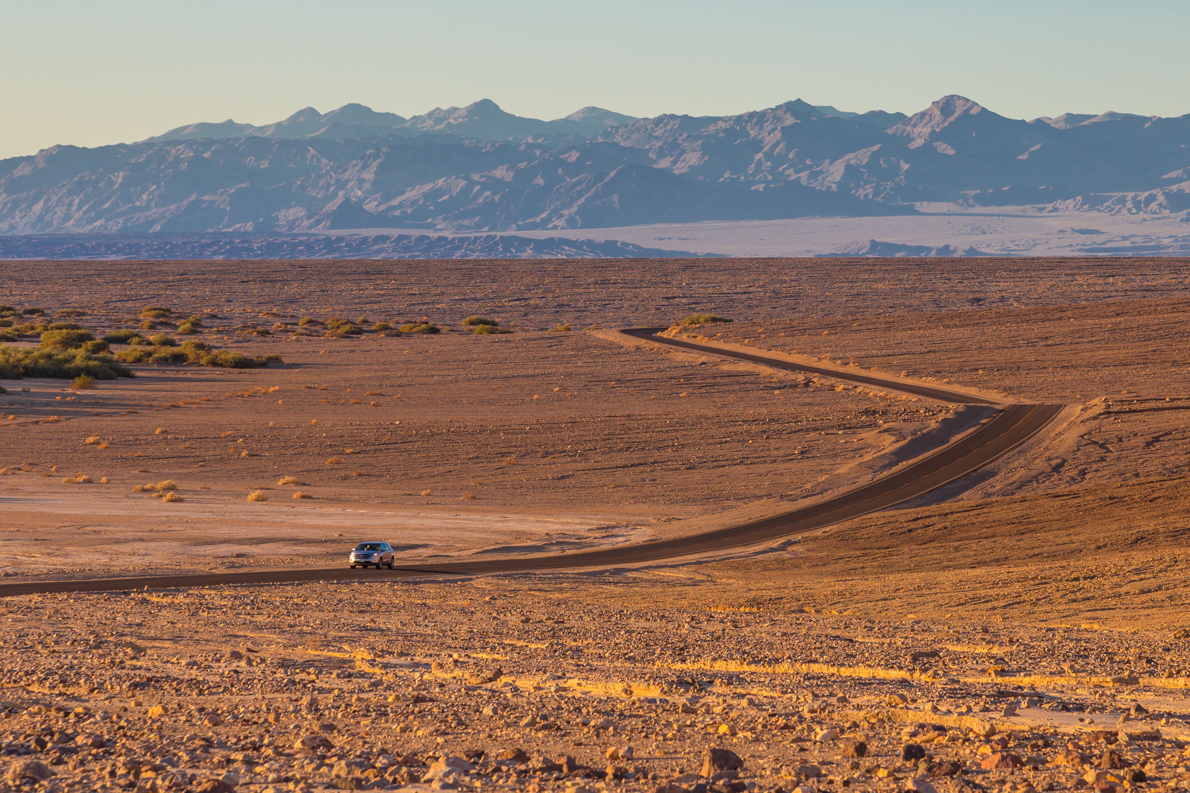 Scenic Desert Road with Mountain Backdrop at Sunset · Free Stock Photo
