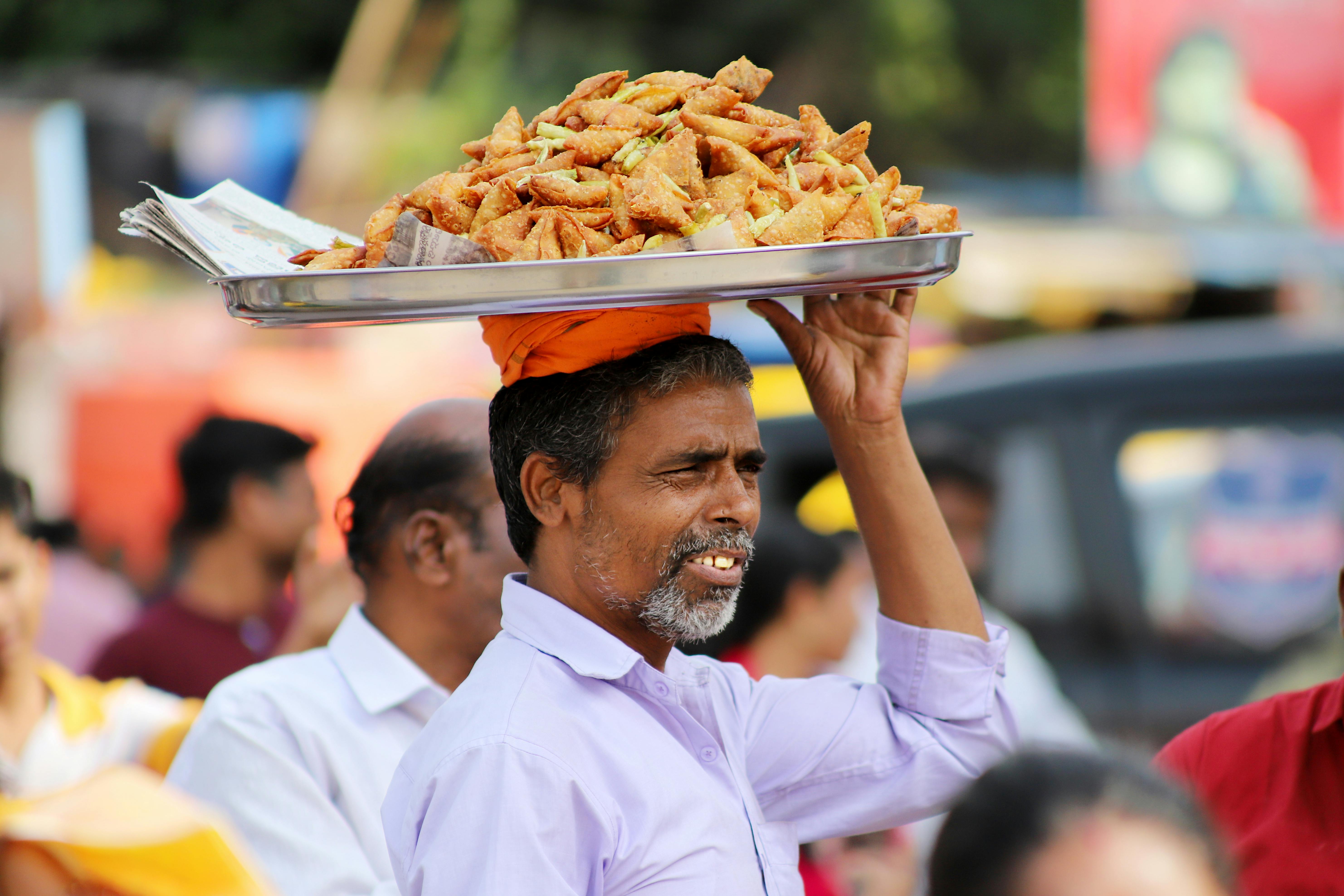 Vendor Carrying Samosas on a Street · Free Stock Photo