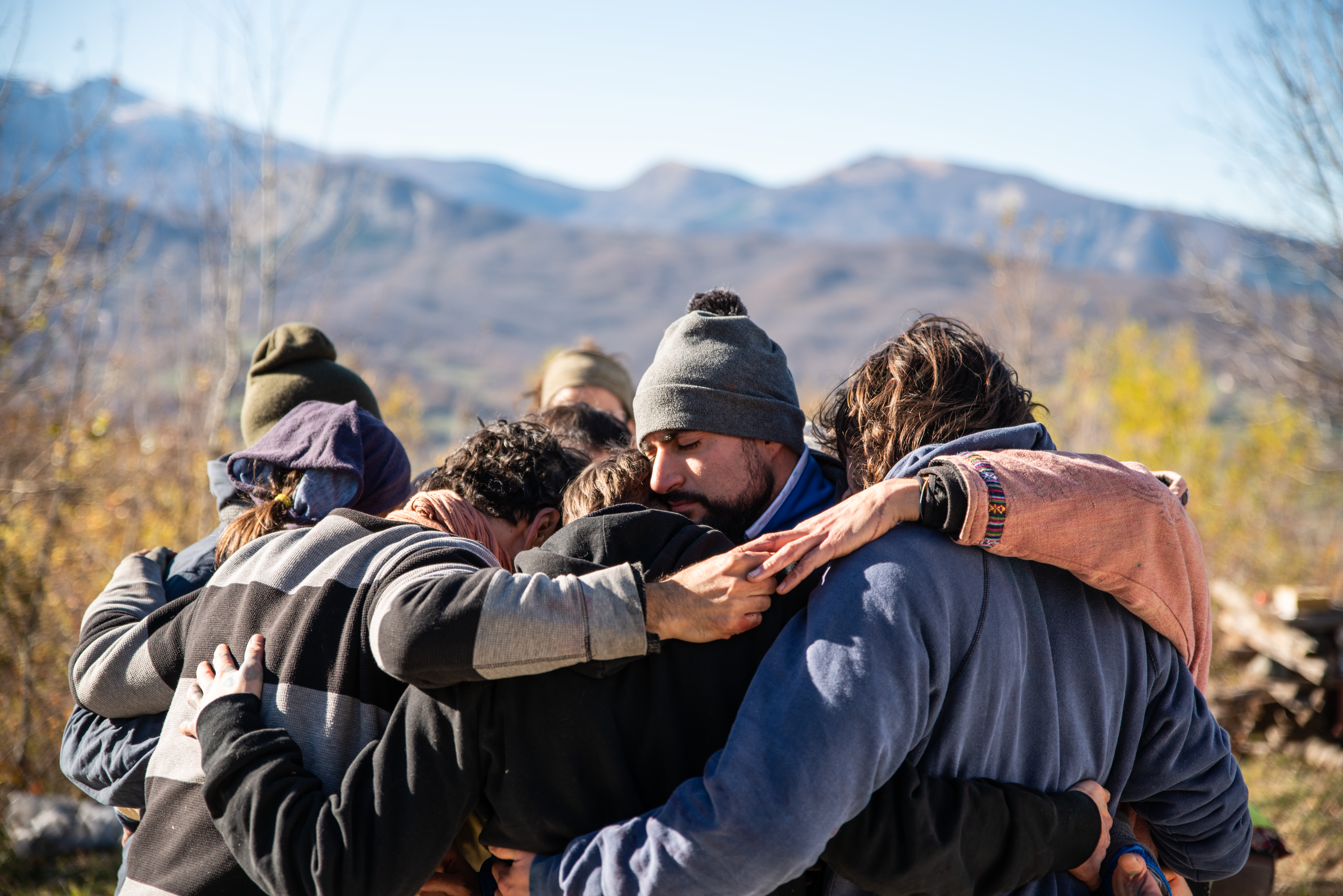 Group Hug in Nature with Mountain Backdrop · Free Stock Photo
