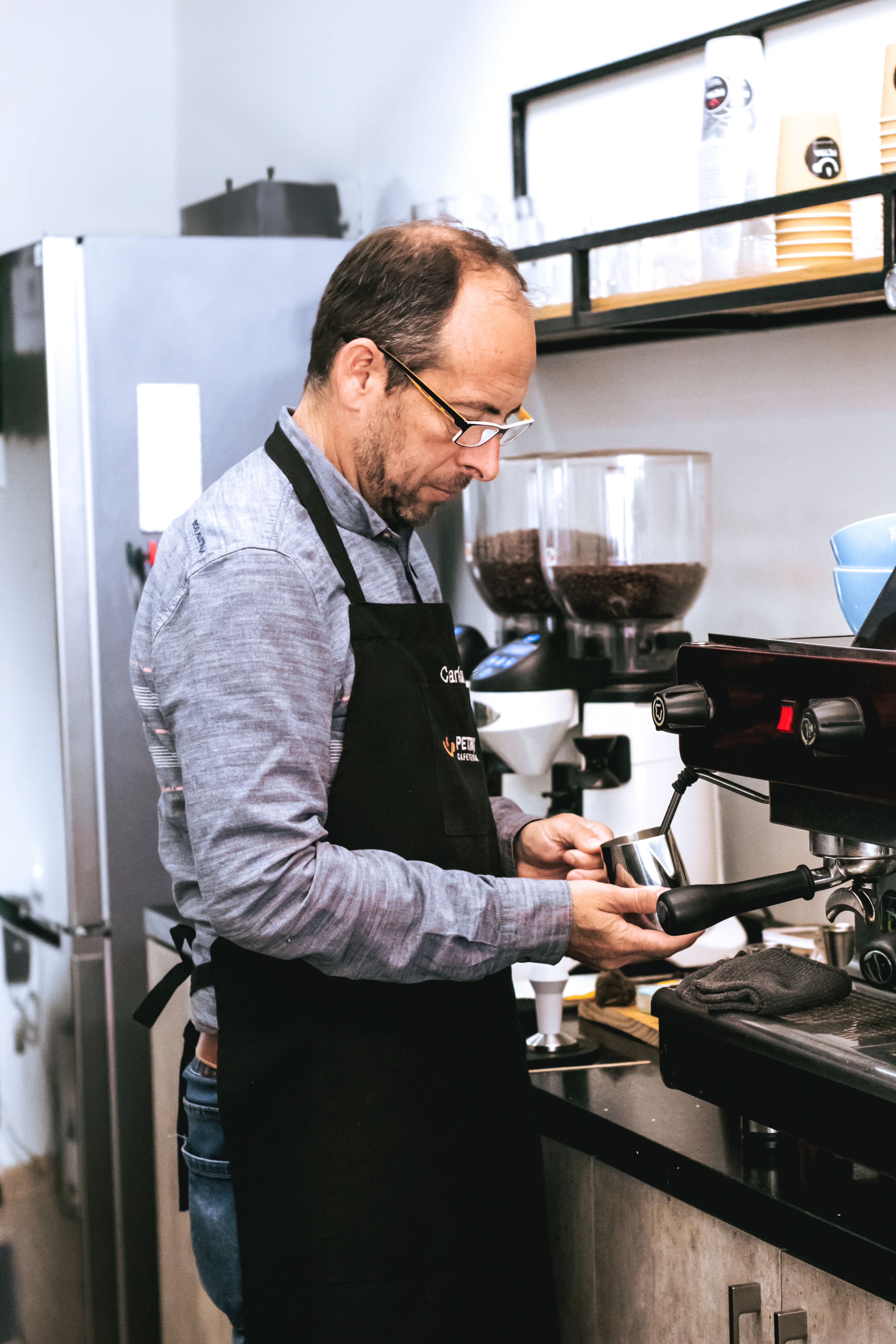 Barista Preparing Coffee in Modern Café Setting · Free Stock Photo
