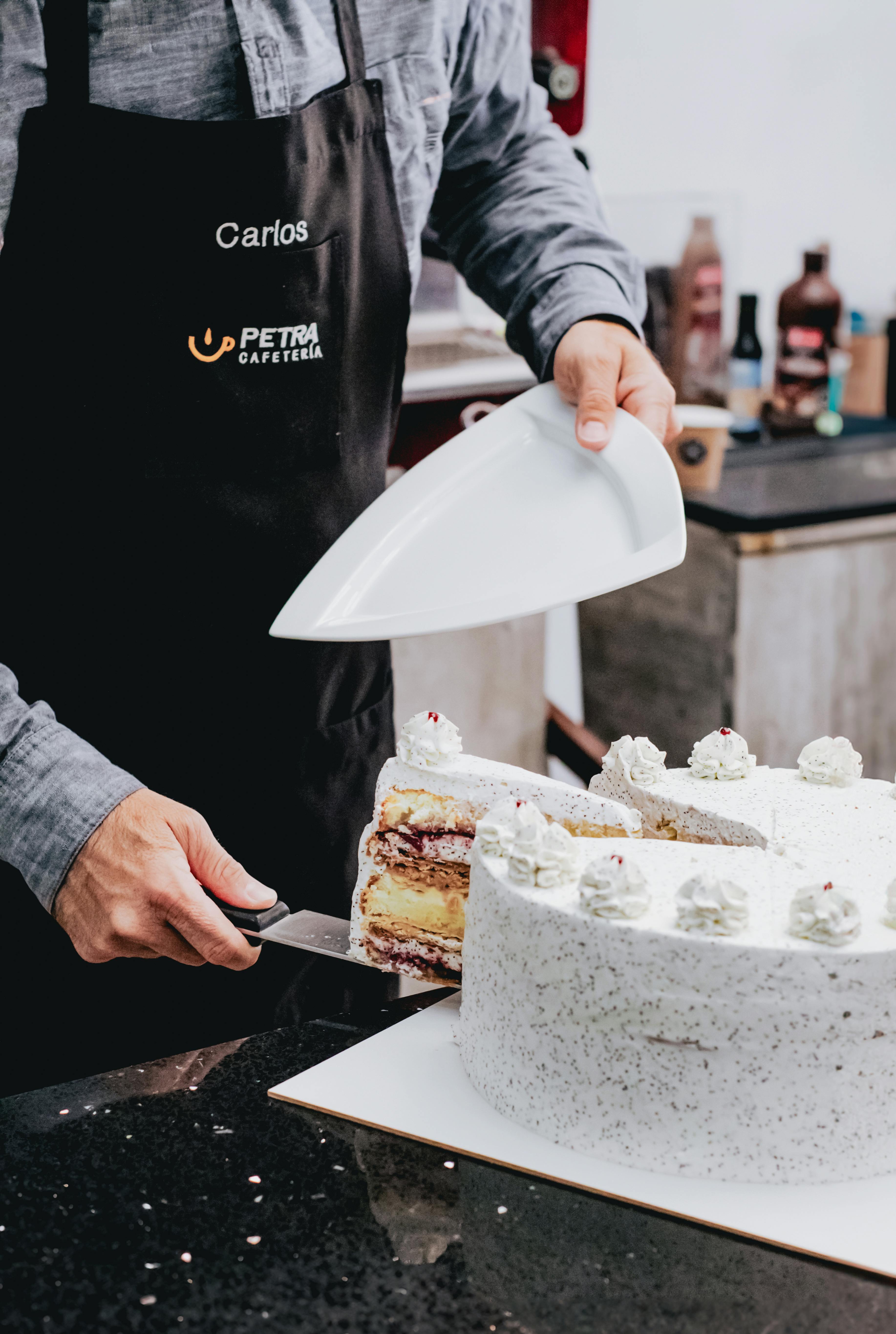Barista Slicing Cake in a Cozy Café Setting · Free Stock Photo