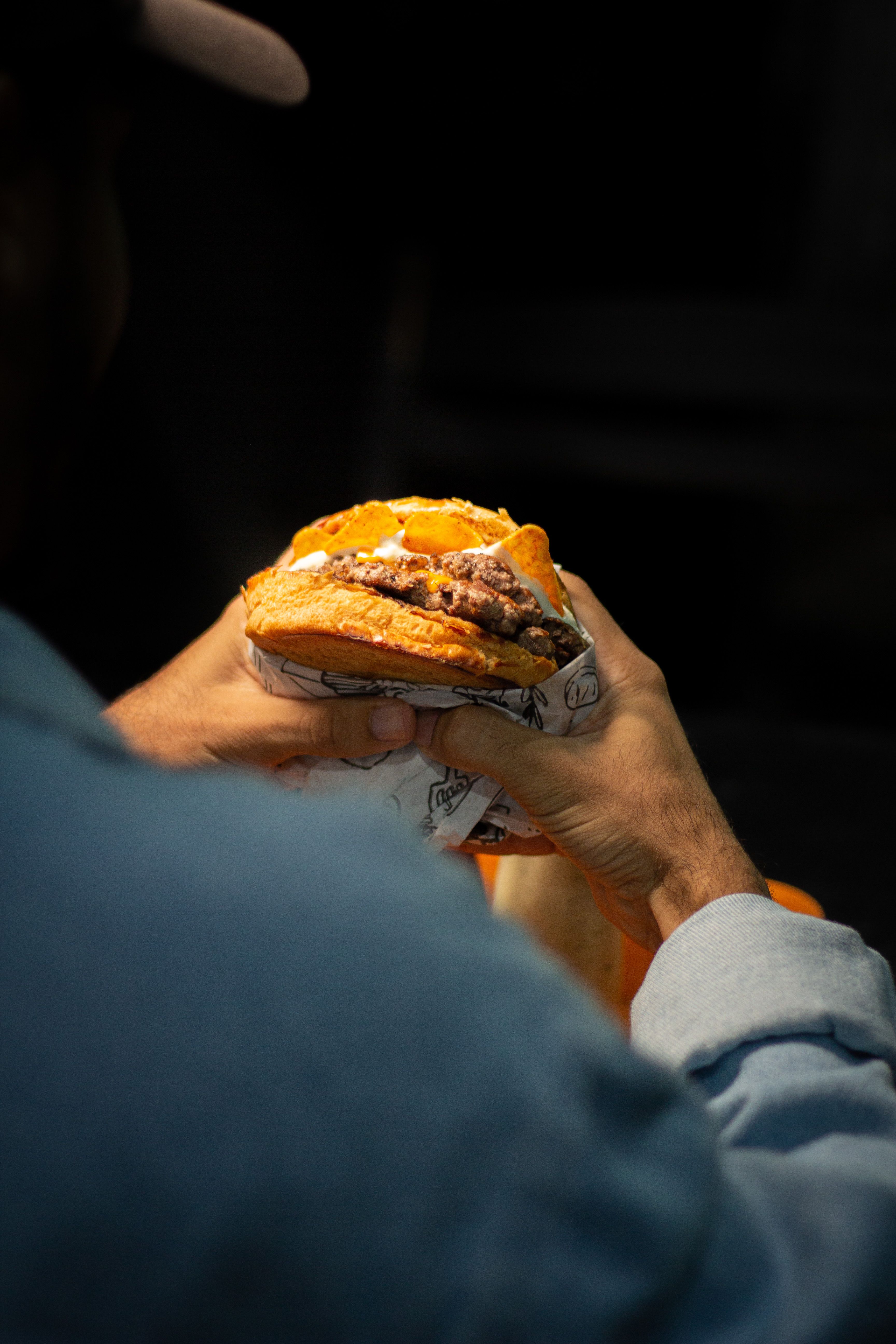 Close-up of Hands Holding a Juicy Burger · Free Stock Photo