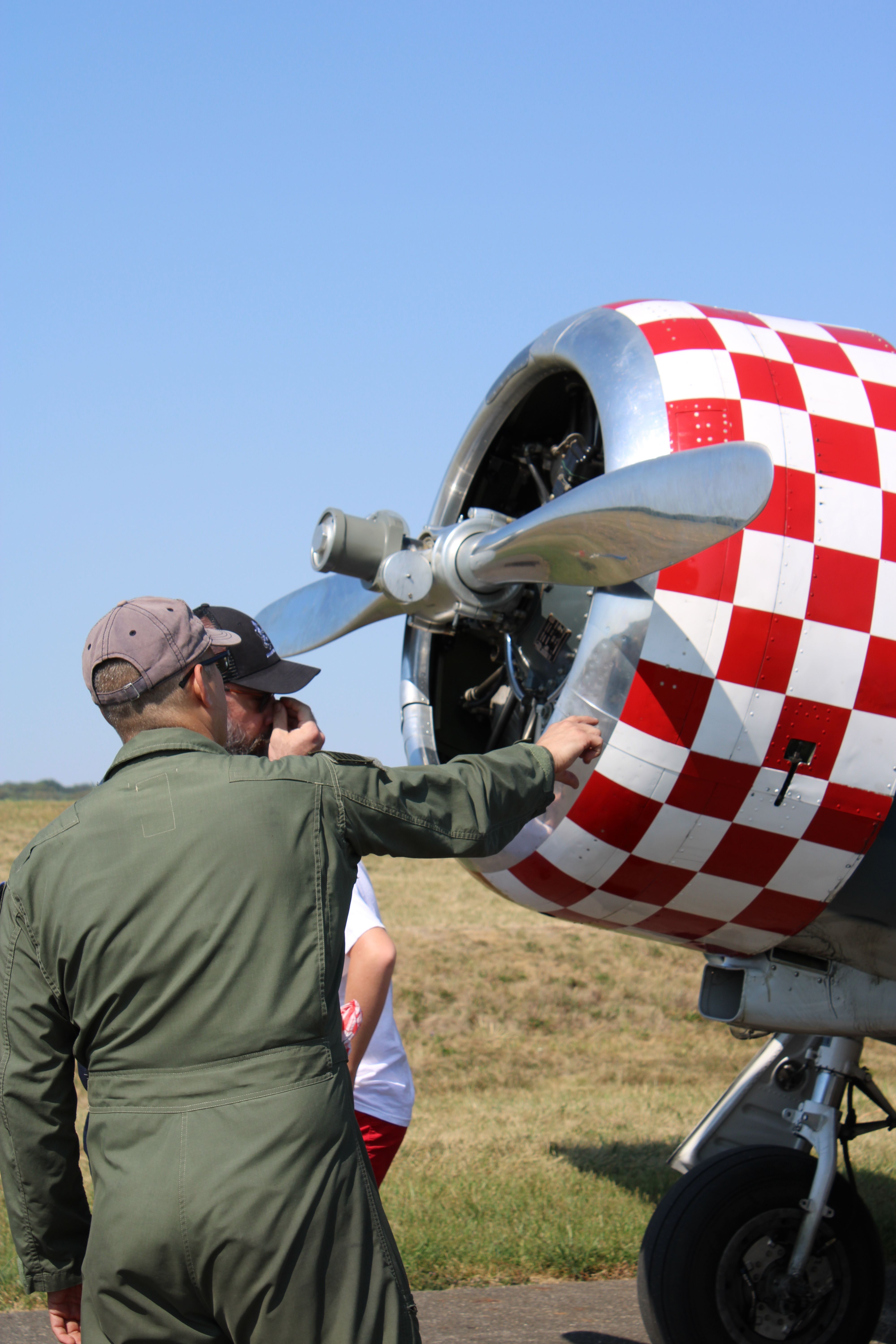 Pilot Inspects T-6 Texan Aircraft Engine Outdoors · Free Stock Photo