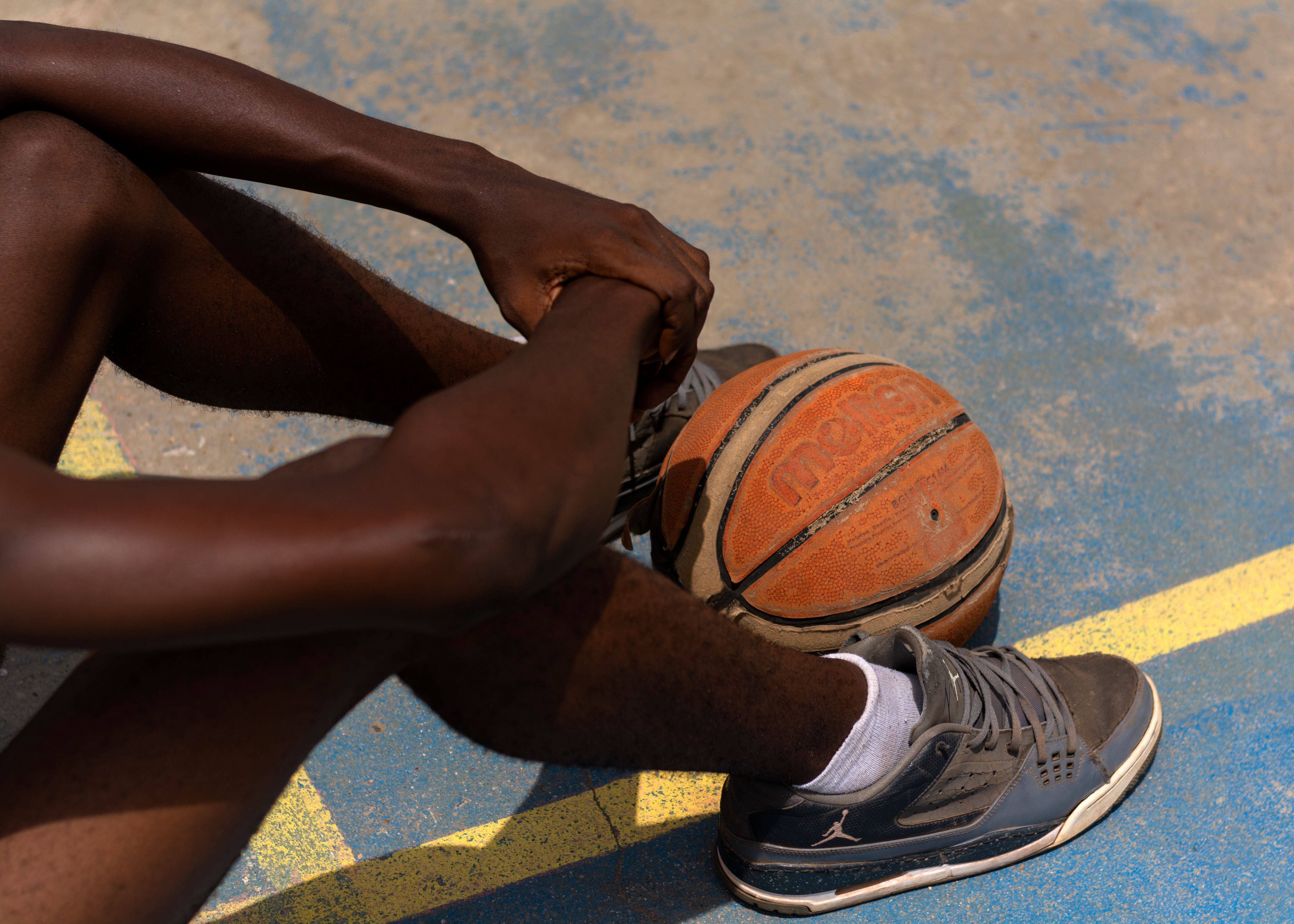 Resting Basketball Player on Outdoor Court · Free Stock Photo