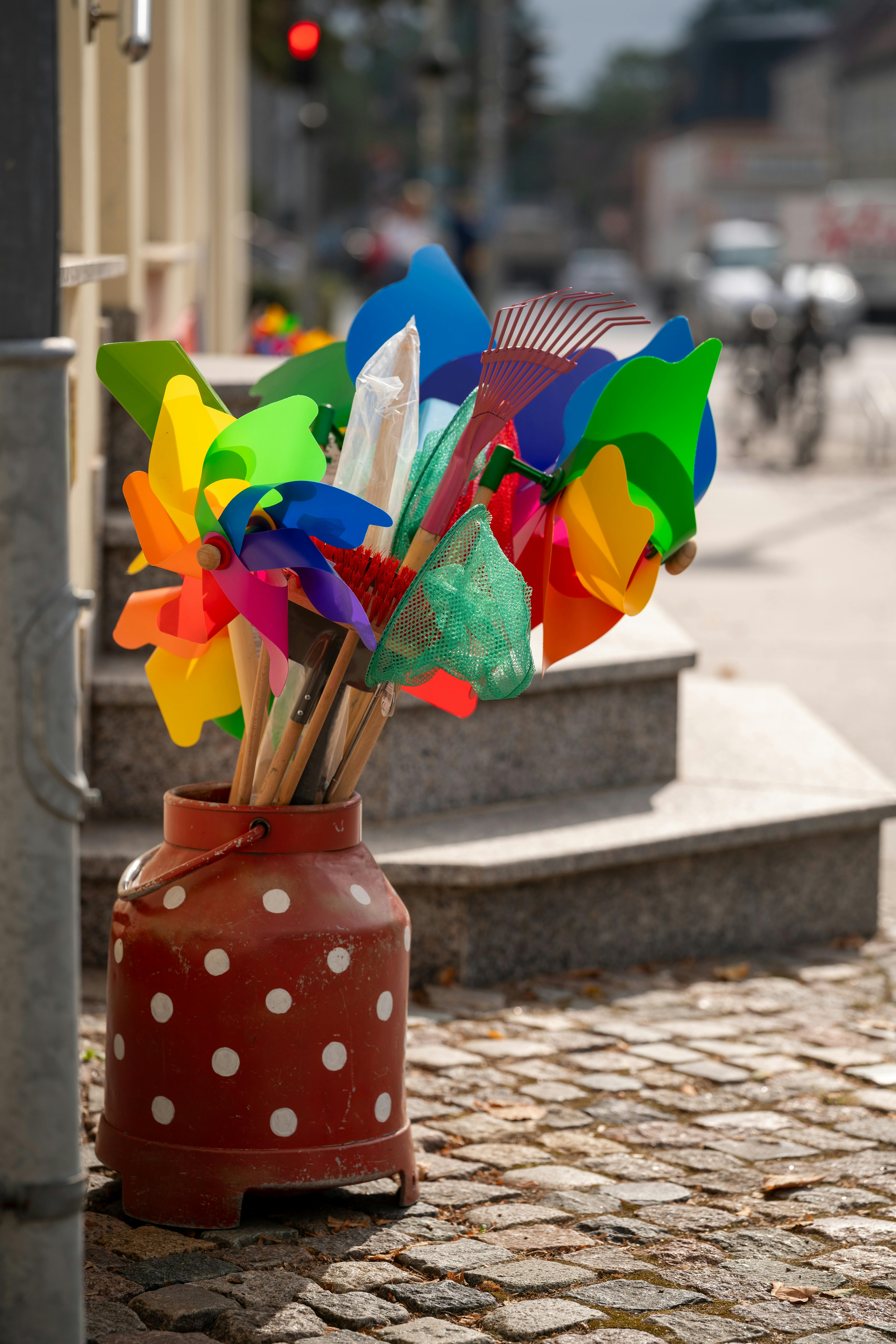 Colorful Pinwheels in Red Polka Dot Vase Outdoors · Free Stock Photo