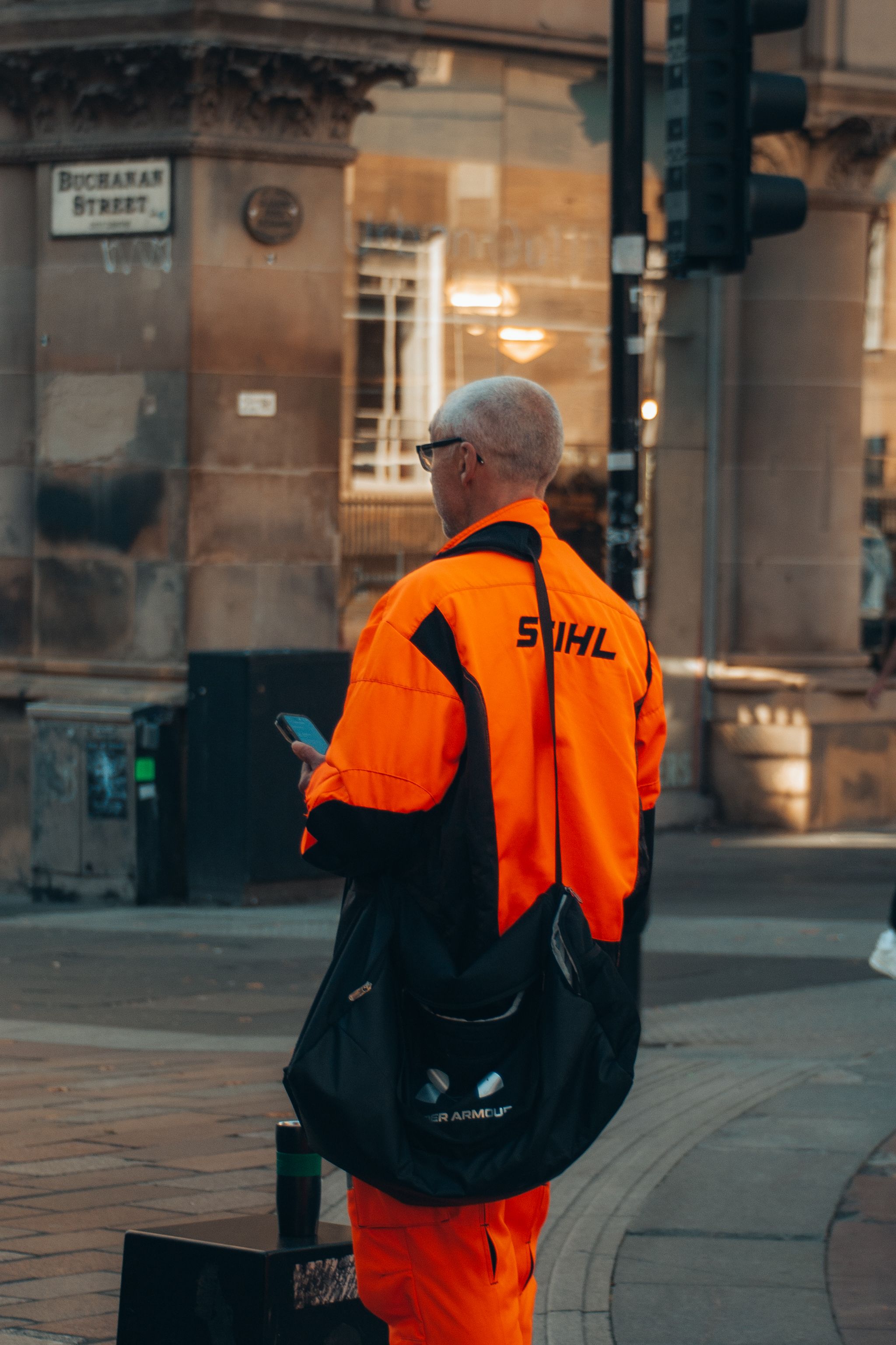 Man in Bright Orange Uniform on City Street · Free Stock Photo