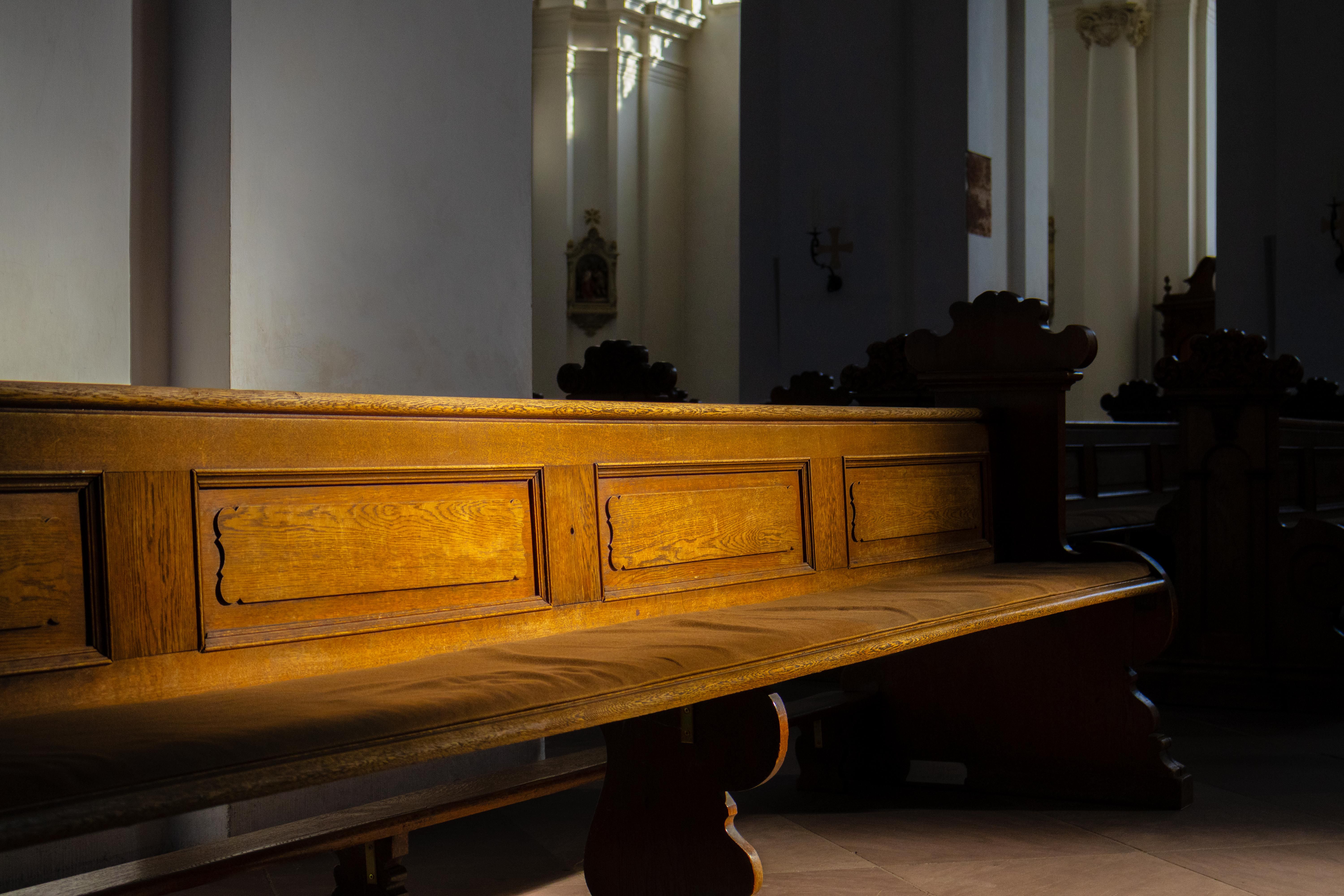 Elegant Wooden Church Pew in Sunlit Church Interior · Free Stock Photo