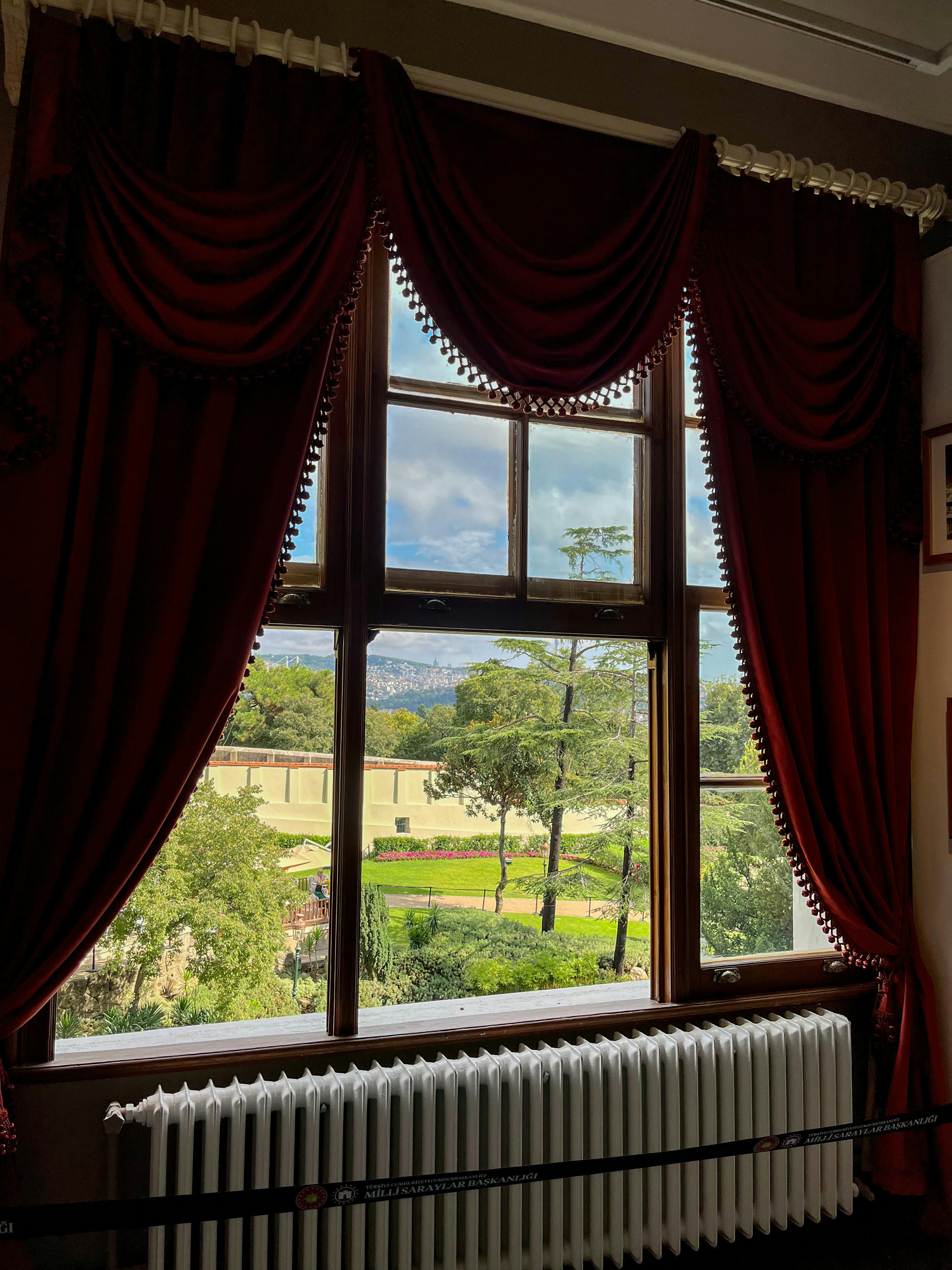 Scenic Garden View Through Elegant Window Curtains · Free Stock Photo