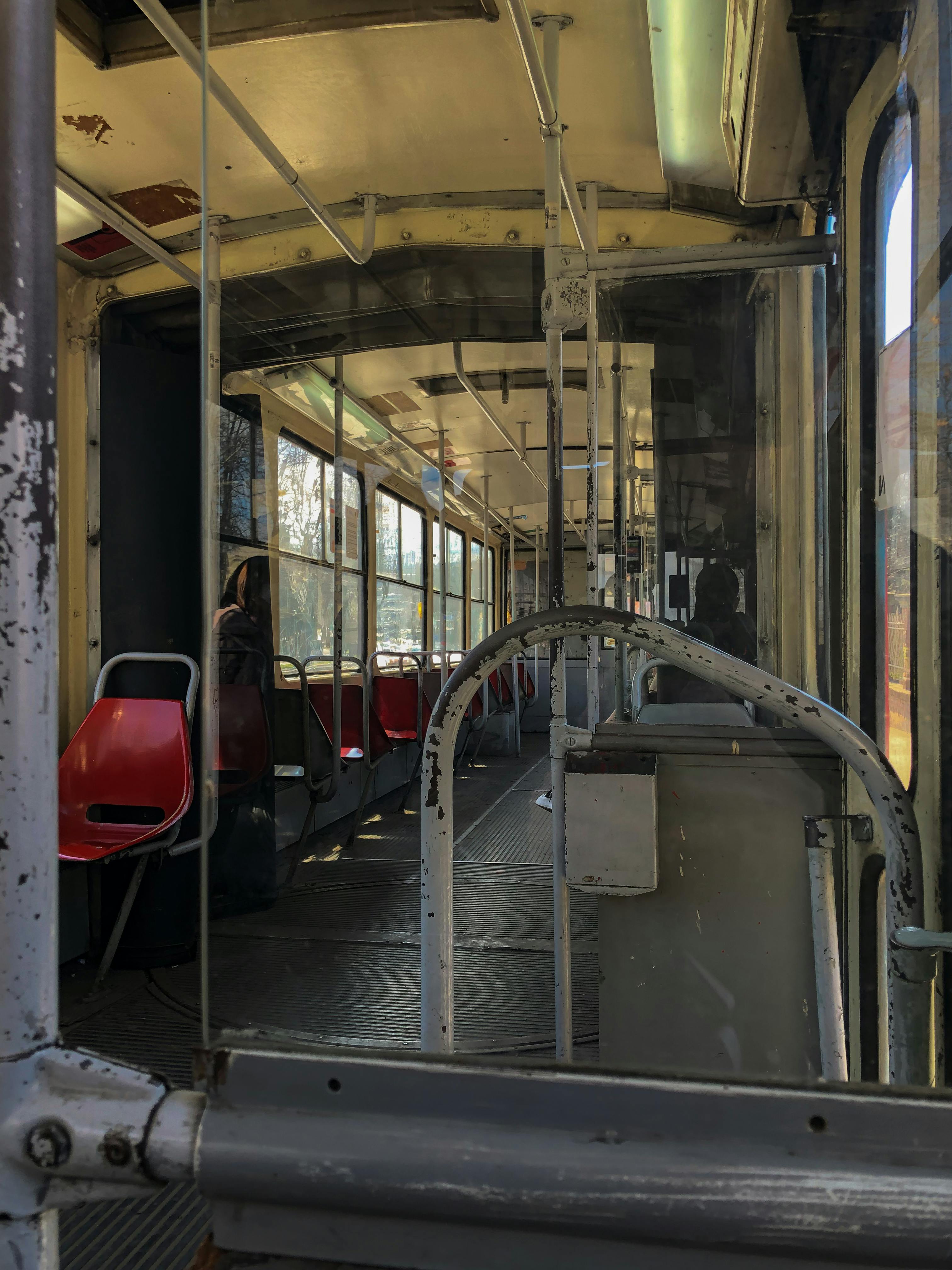 Vintage Tram Interior with Red Seats and Rusty Frame · Free Stock Photo